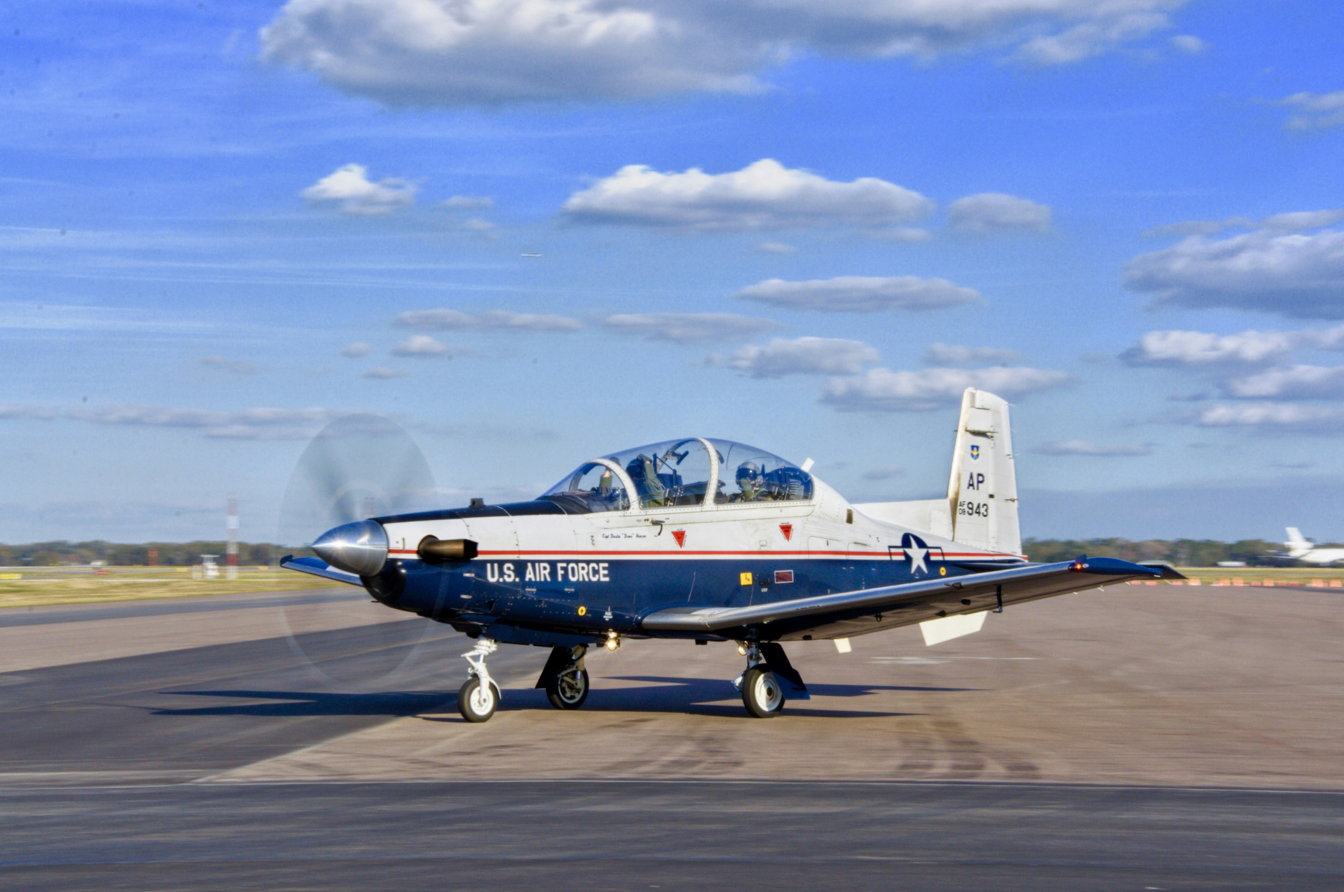 Blue and red jet plane on gray concrete ground under white clouds and ...