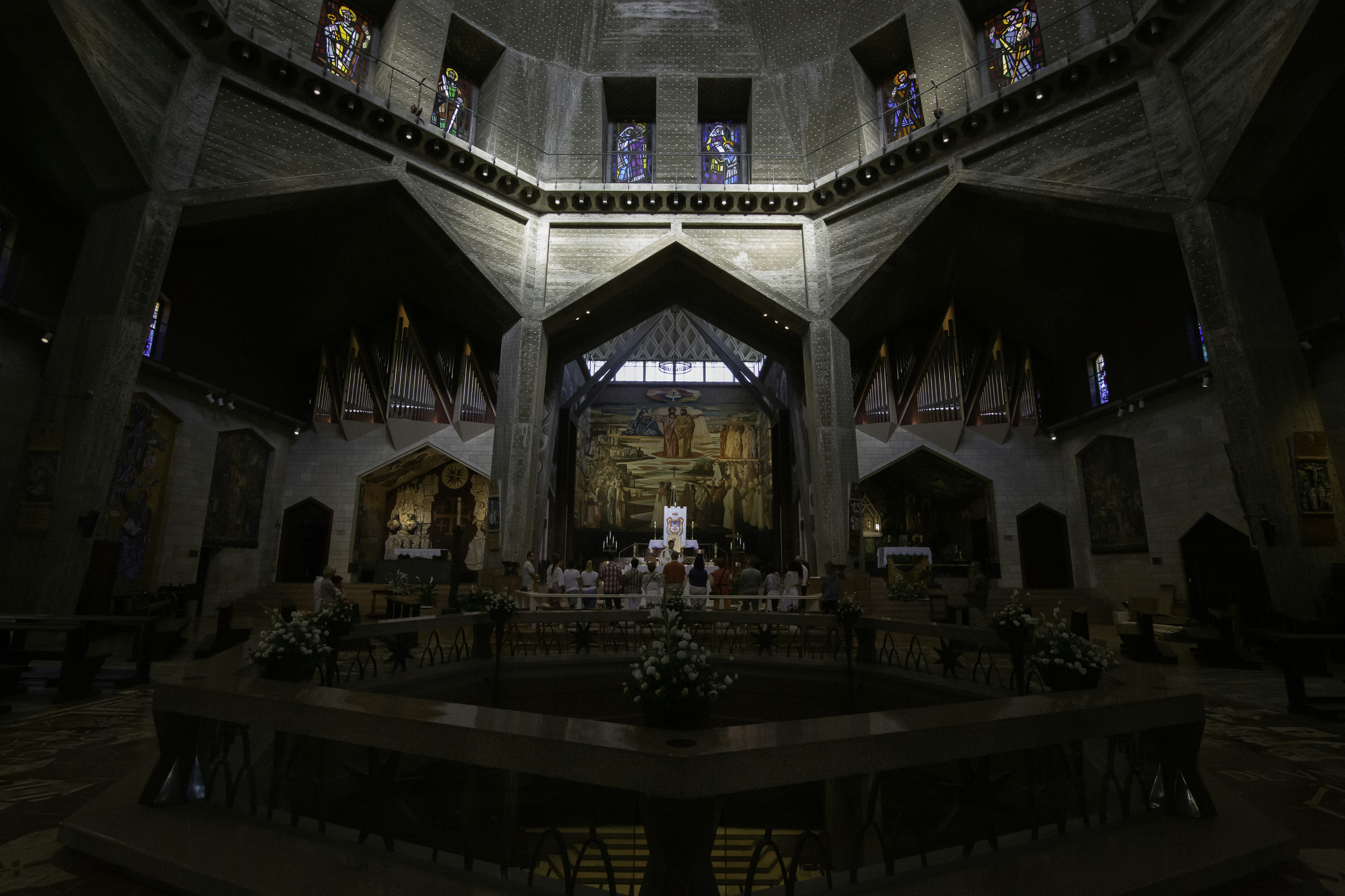 Ornate church interior with high ceilings and intricate designs, captured in dim lighting.