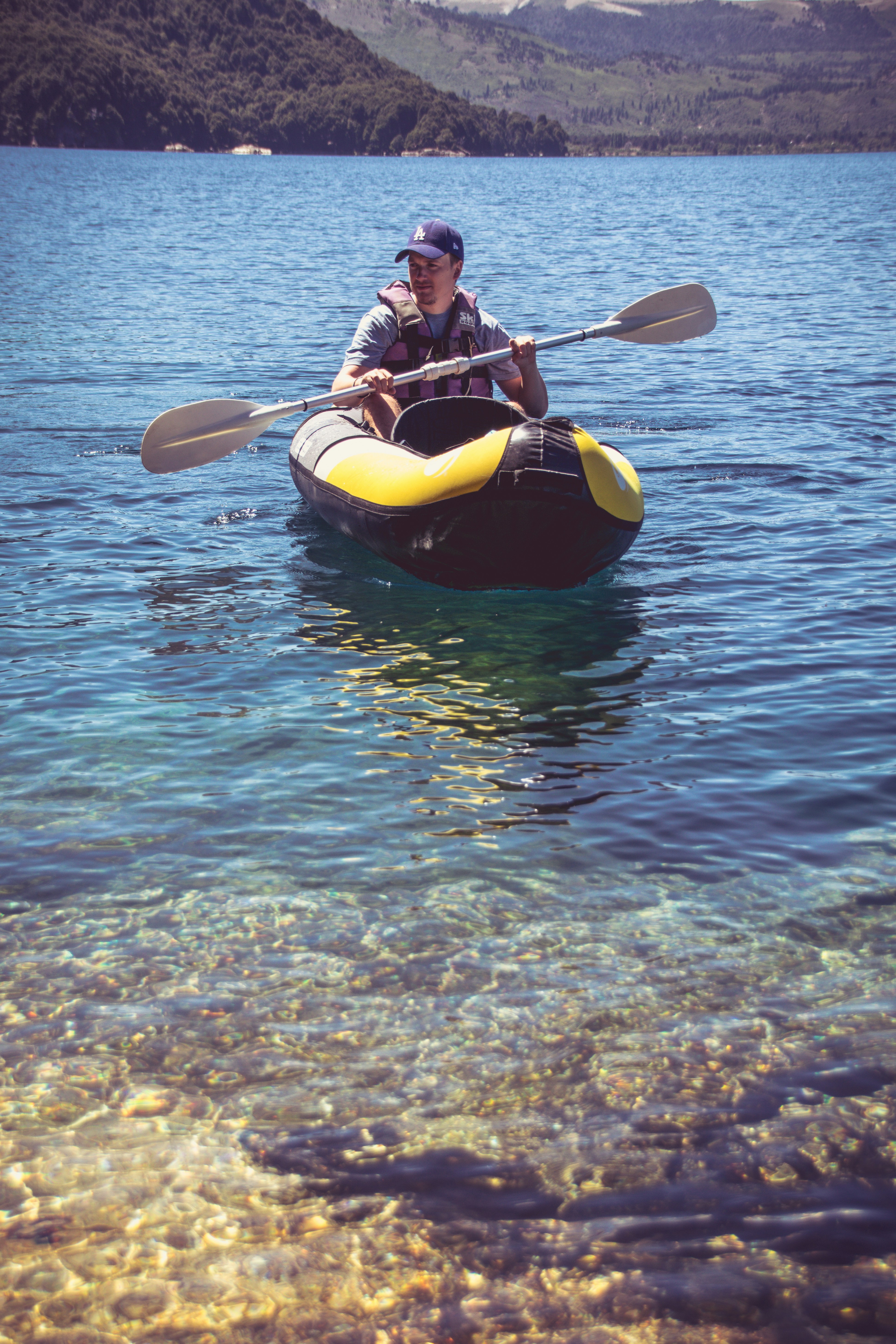Woman in black and yellow dress riding on yellow kayak on body of water ...