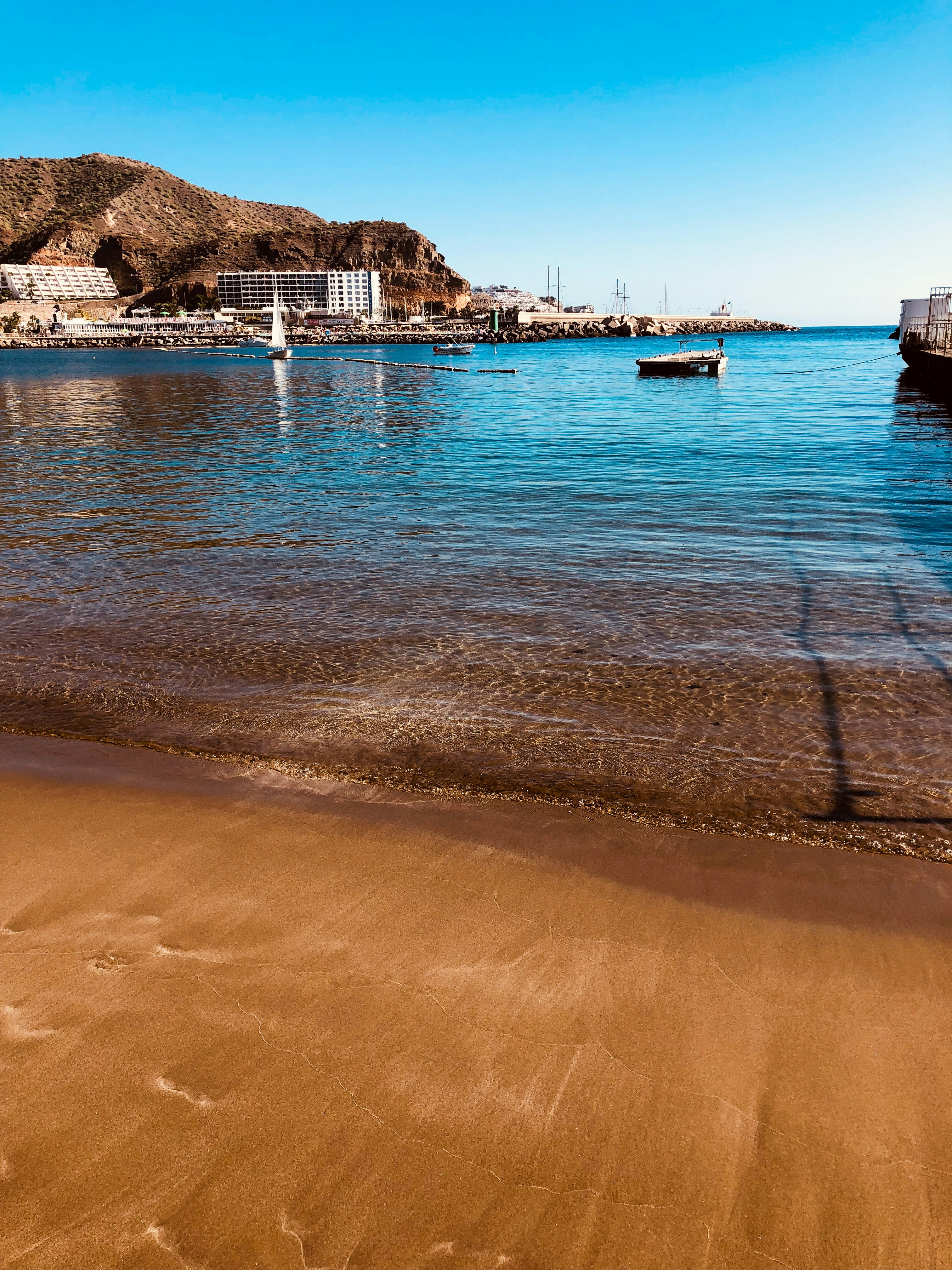 Harbor Edge: Boats, Cliffside Town, and a Quiet Beach Morning