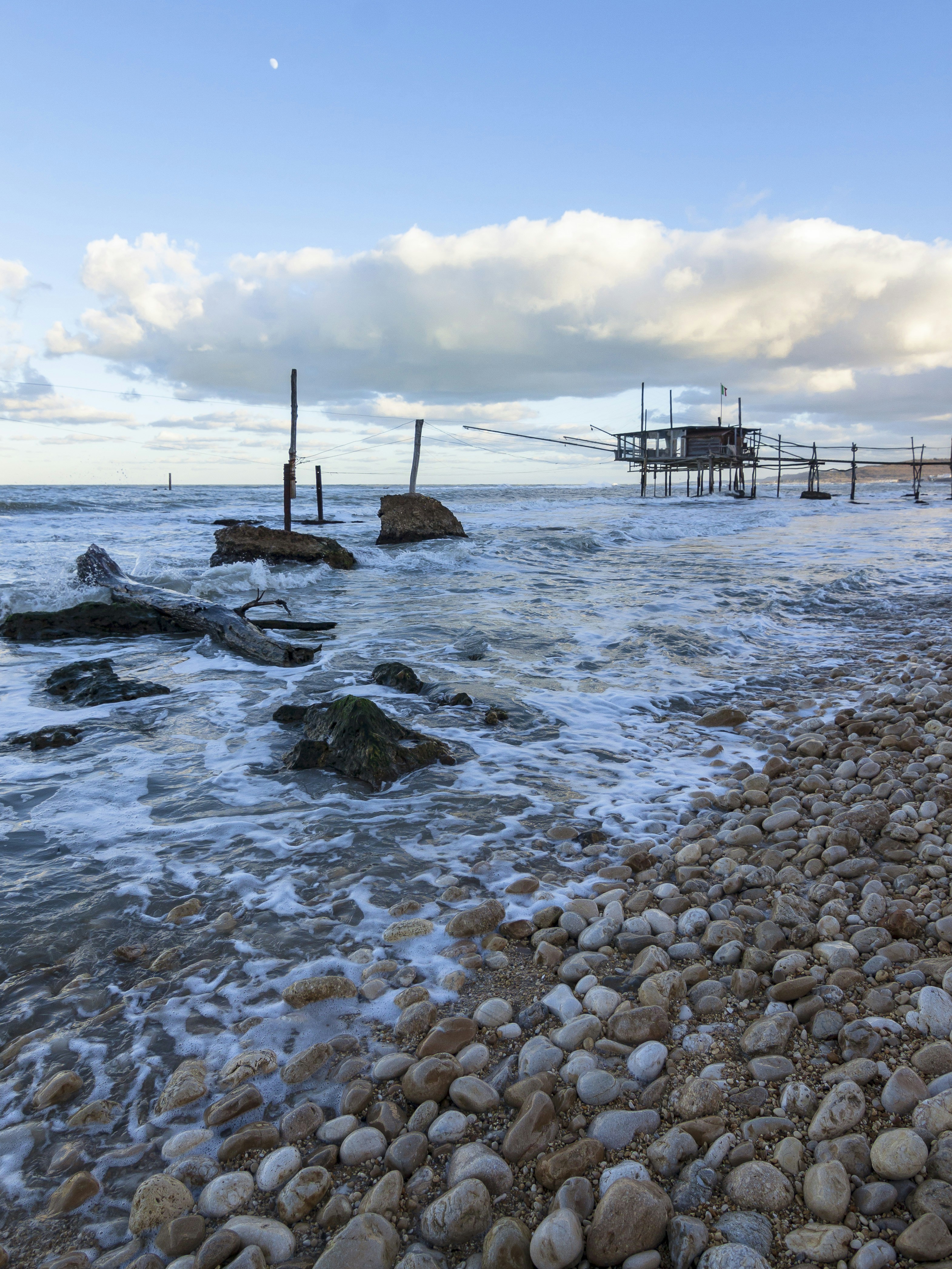 brown wooden dock on sea under blue sky during daytime