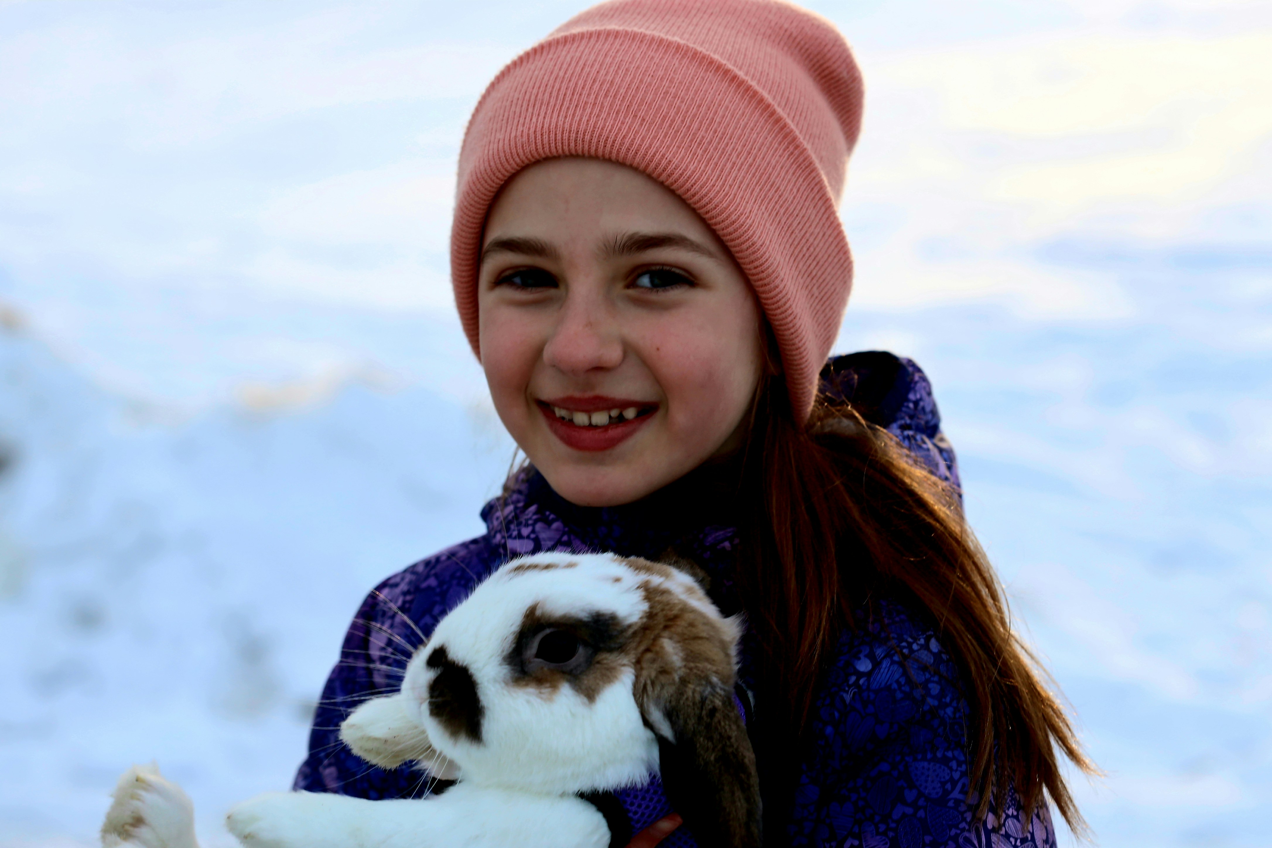 Winter Warmth: A girl and her puppy in a pale blue snowscape
