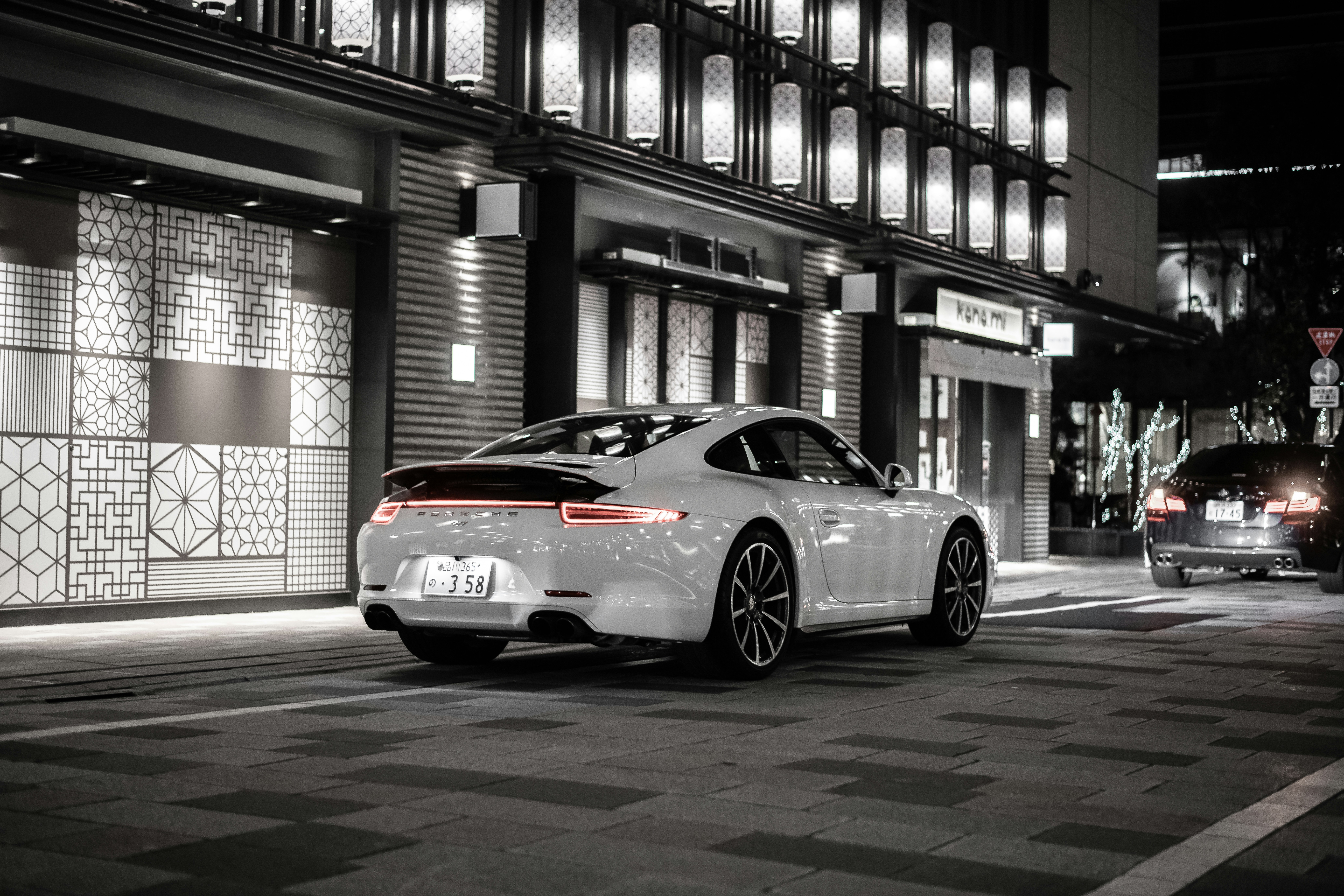 Foto Porsche 911 plateado estacionado cerca de un edificio blanco y ...