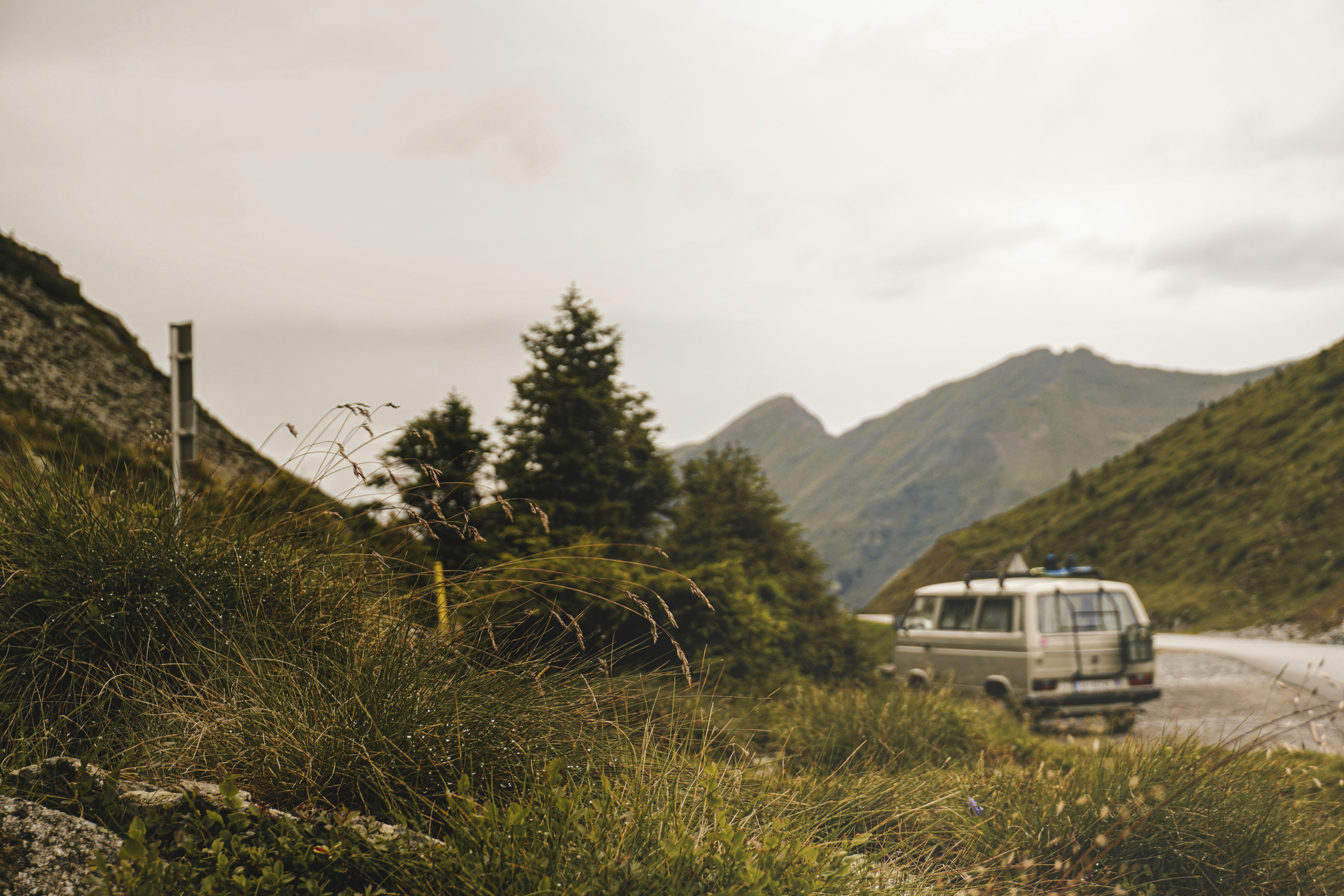 Alpine Curve: Weathered Van on a Quiet Mountain Road