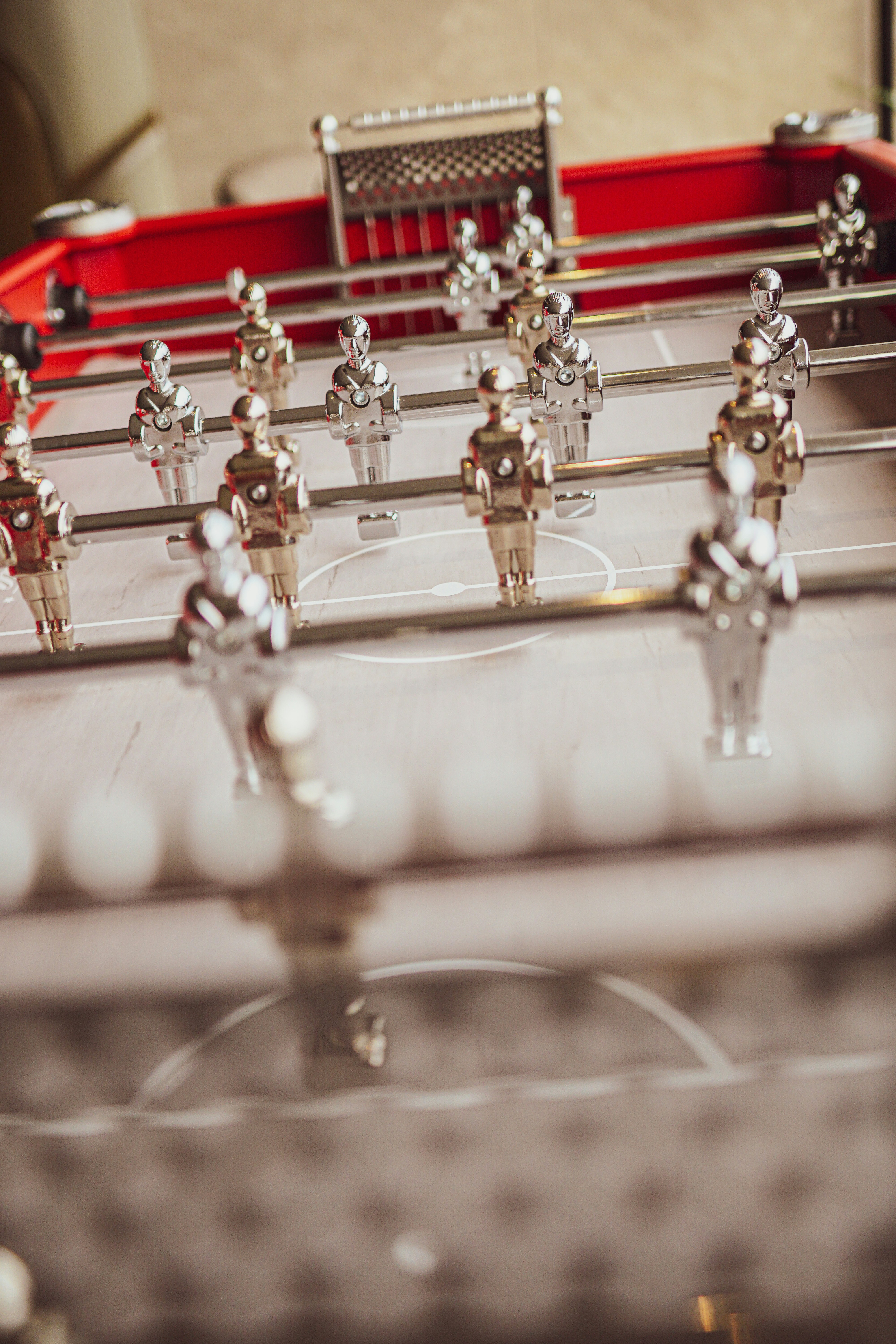Chrome Foosball Troopers Guard a War-Worn Table Under Warm Indoor Light