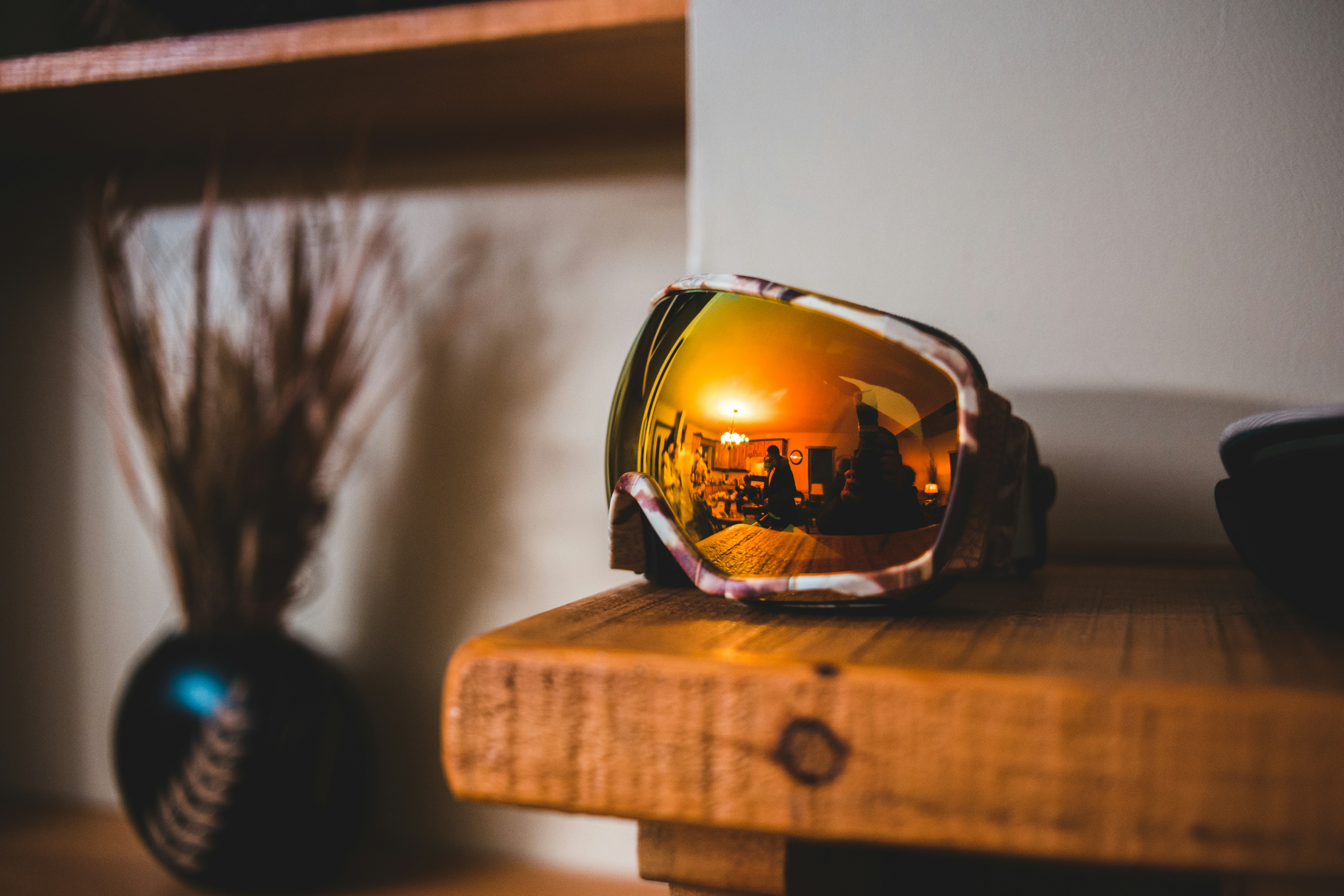 Amber Mirror Goggles Rest on a Wooden Table Under Warm Studio Light
