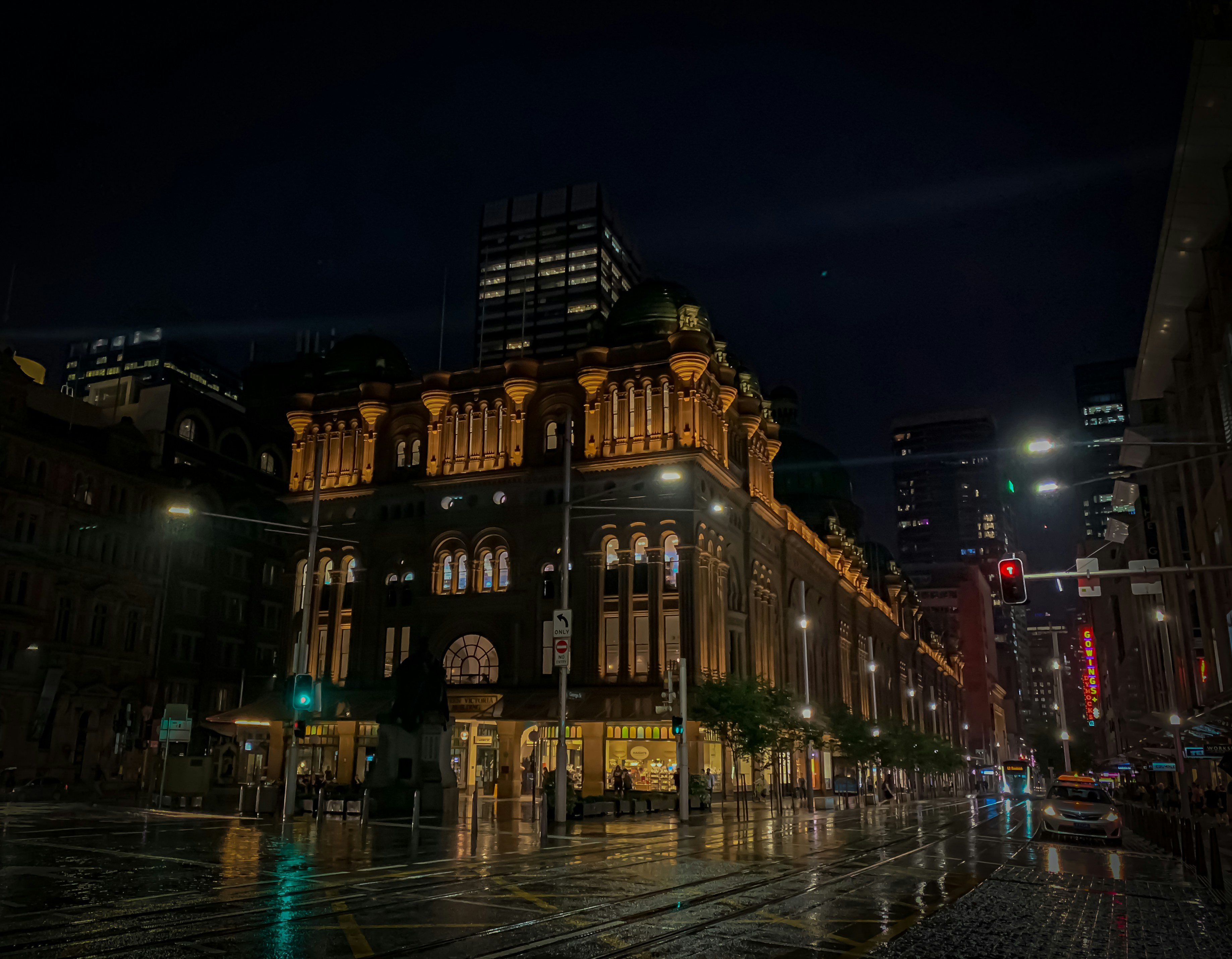 Gold Arches Glowing on a Rain-Slick Night in a Historic City Block