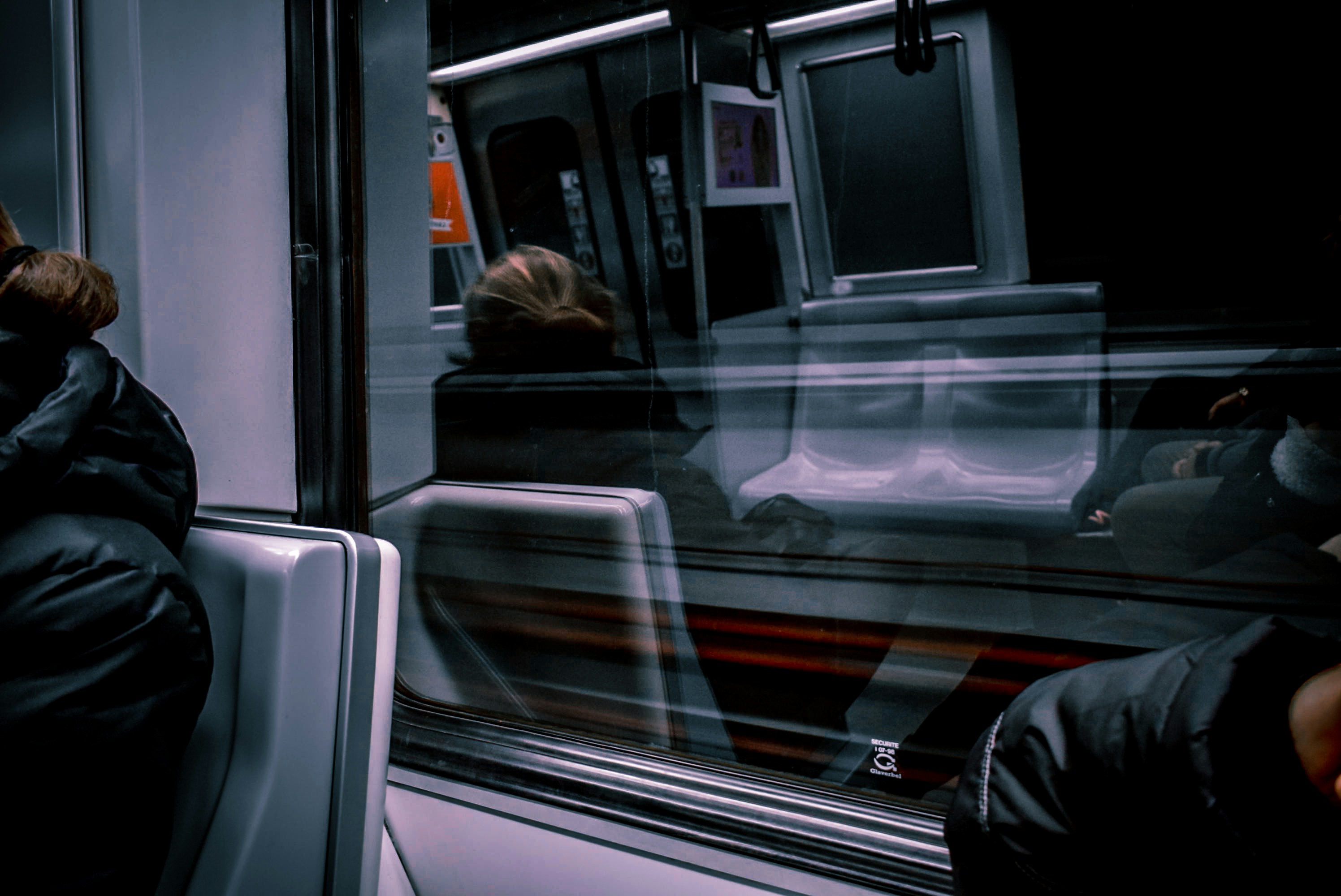 Gliding Subway Window: Quiet Faces and Reflections in Motion