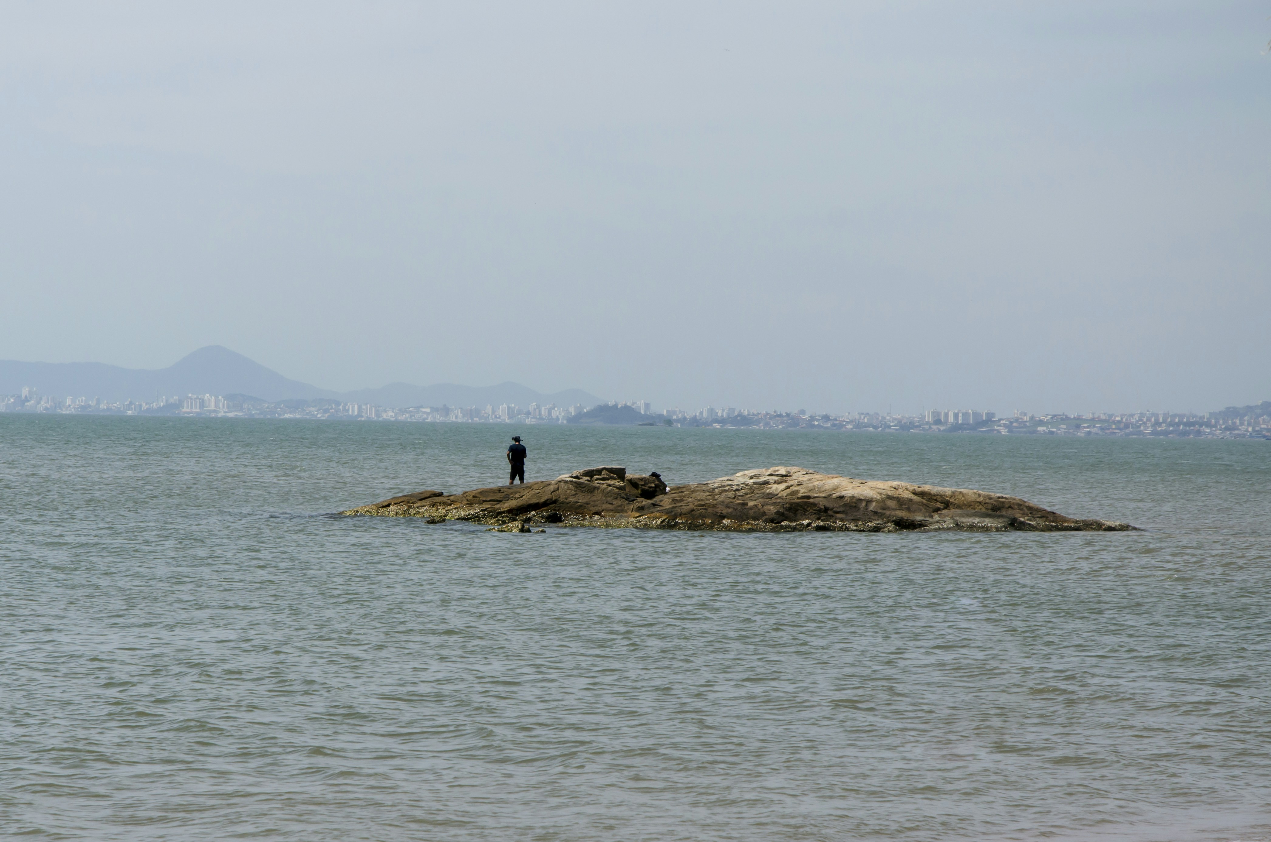 Solitary Figure on a Distant Rock