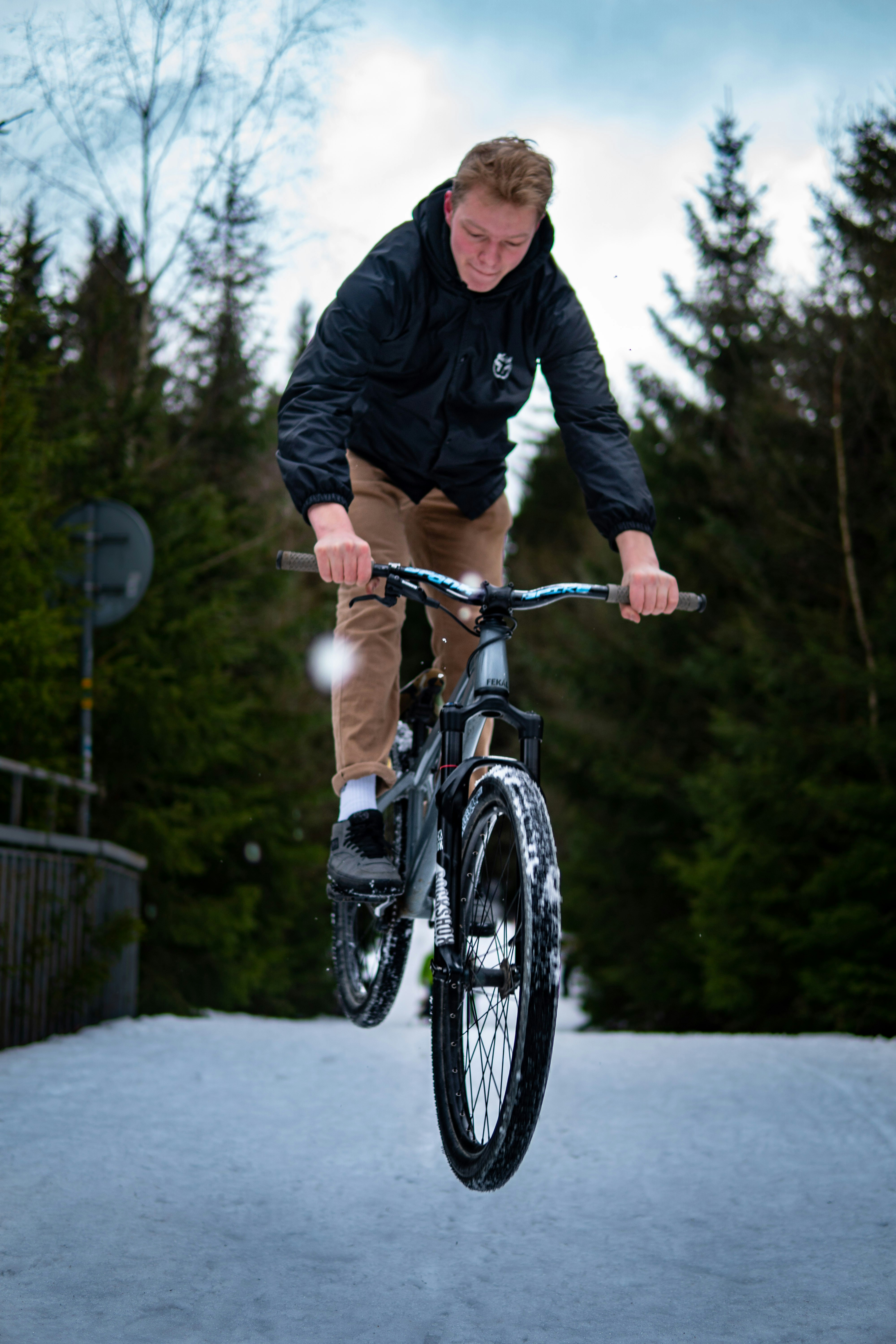 Mid-Air Momentum: Street Rider Clears the Snow Cushioned by a Winter Forest