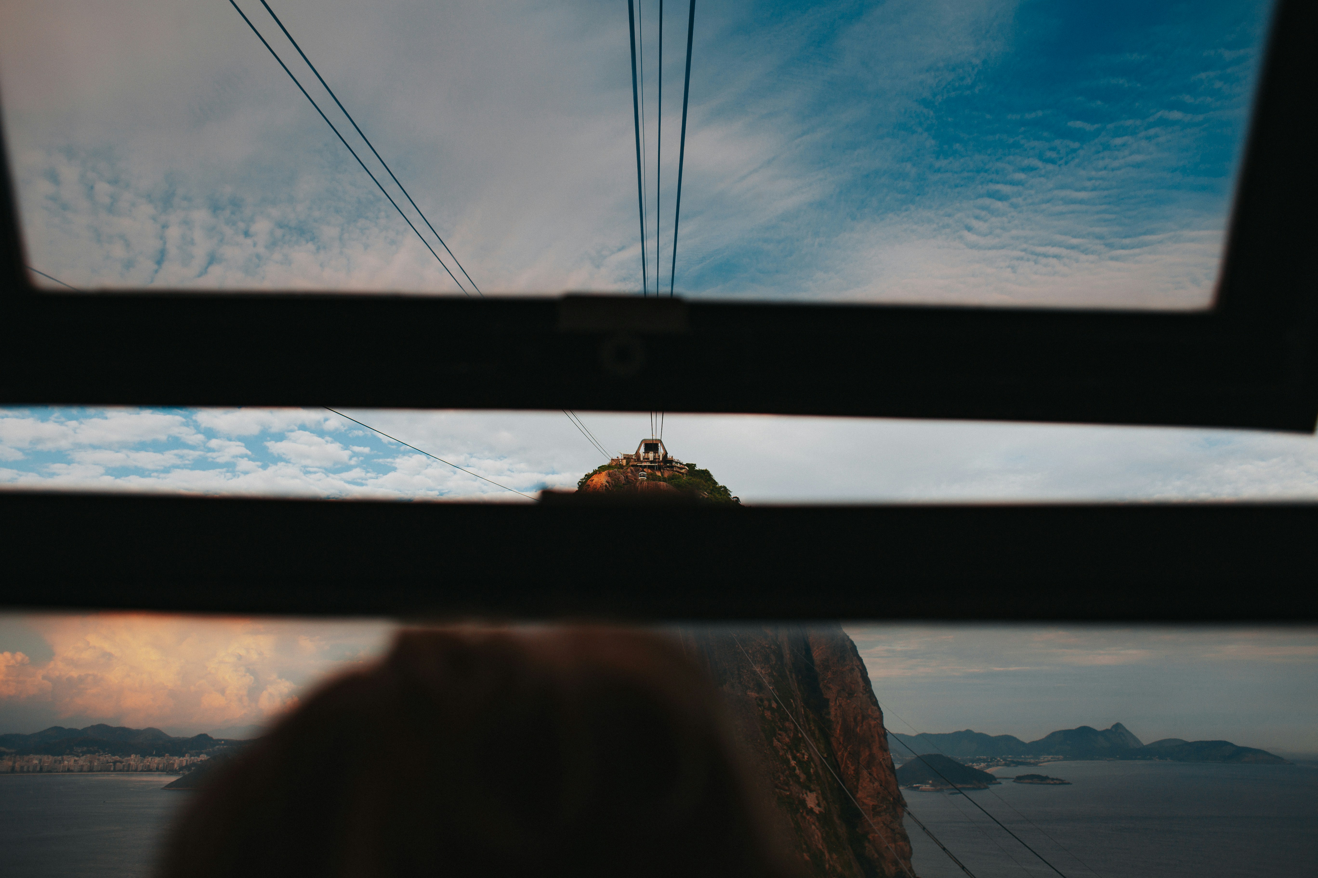 Gondola Crossing Above a Cliff-Island: Cables, Sea, and Sky