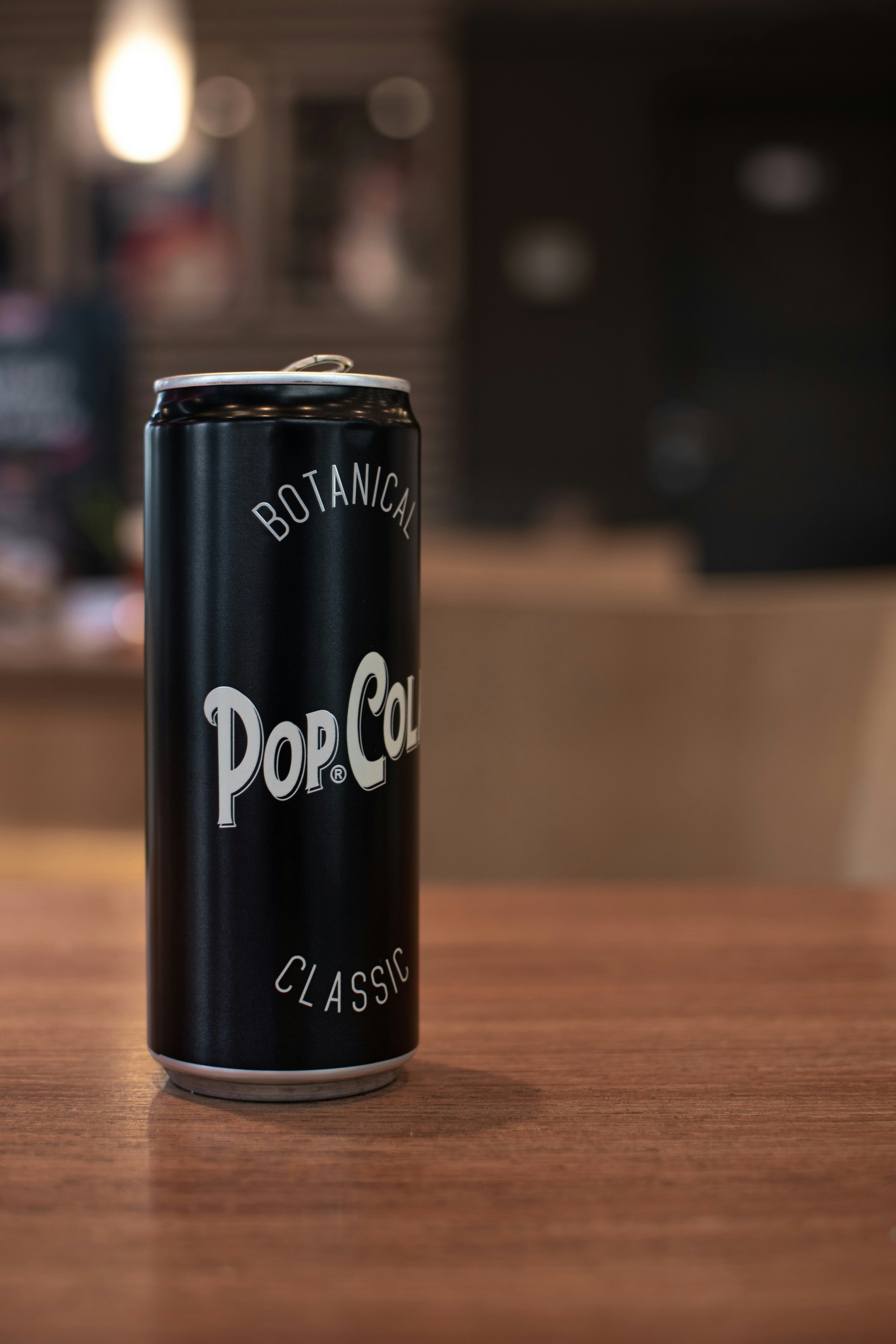 Botanical Black: Pop Cola Can on a Quiet Bar Table