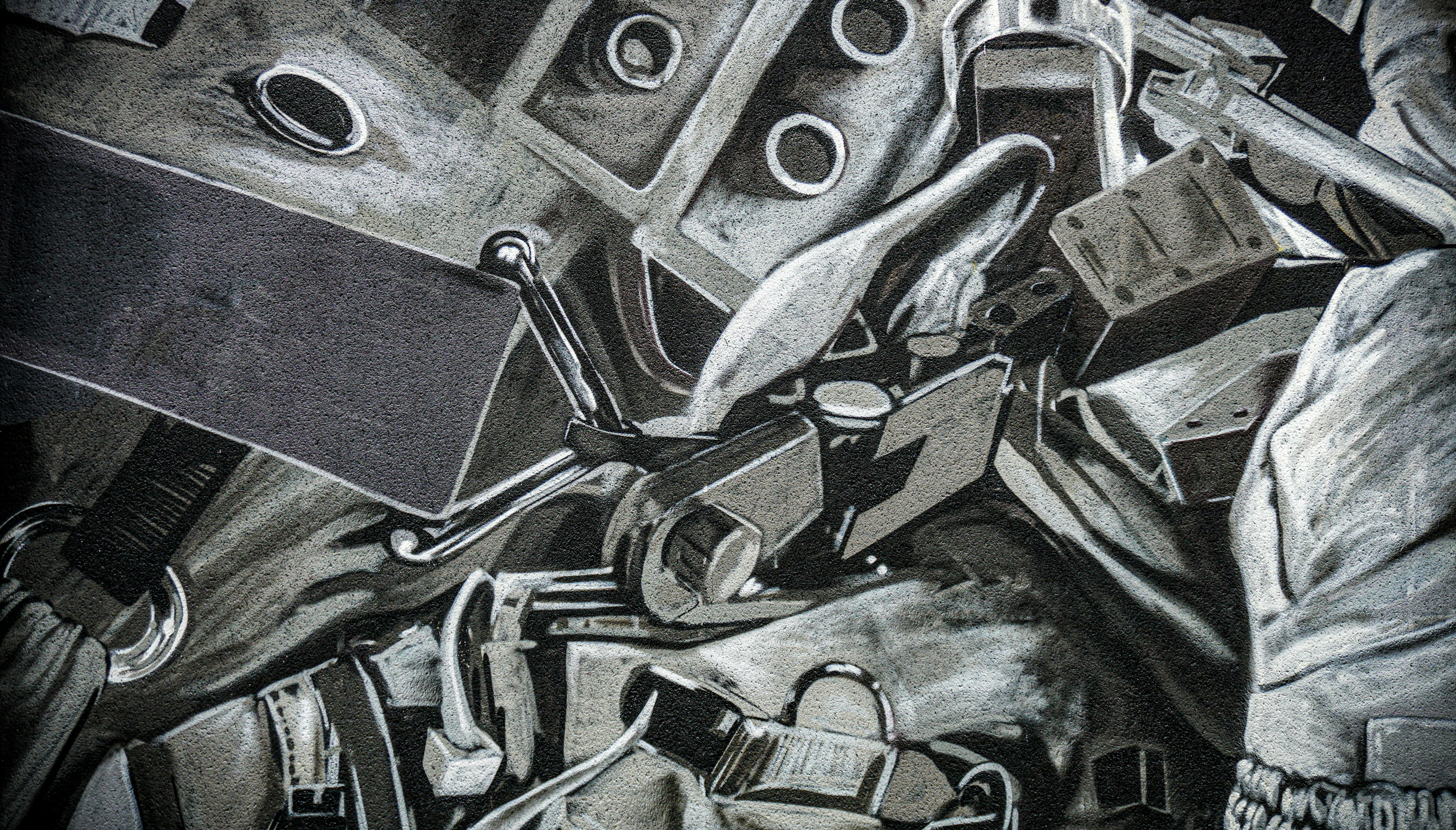 An intricate arrangement of tools and mechanical components, showcasing their textures and forms in monochrome. The composition highlights the complexity of machinery.