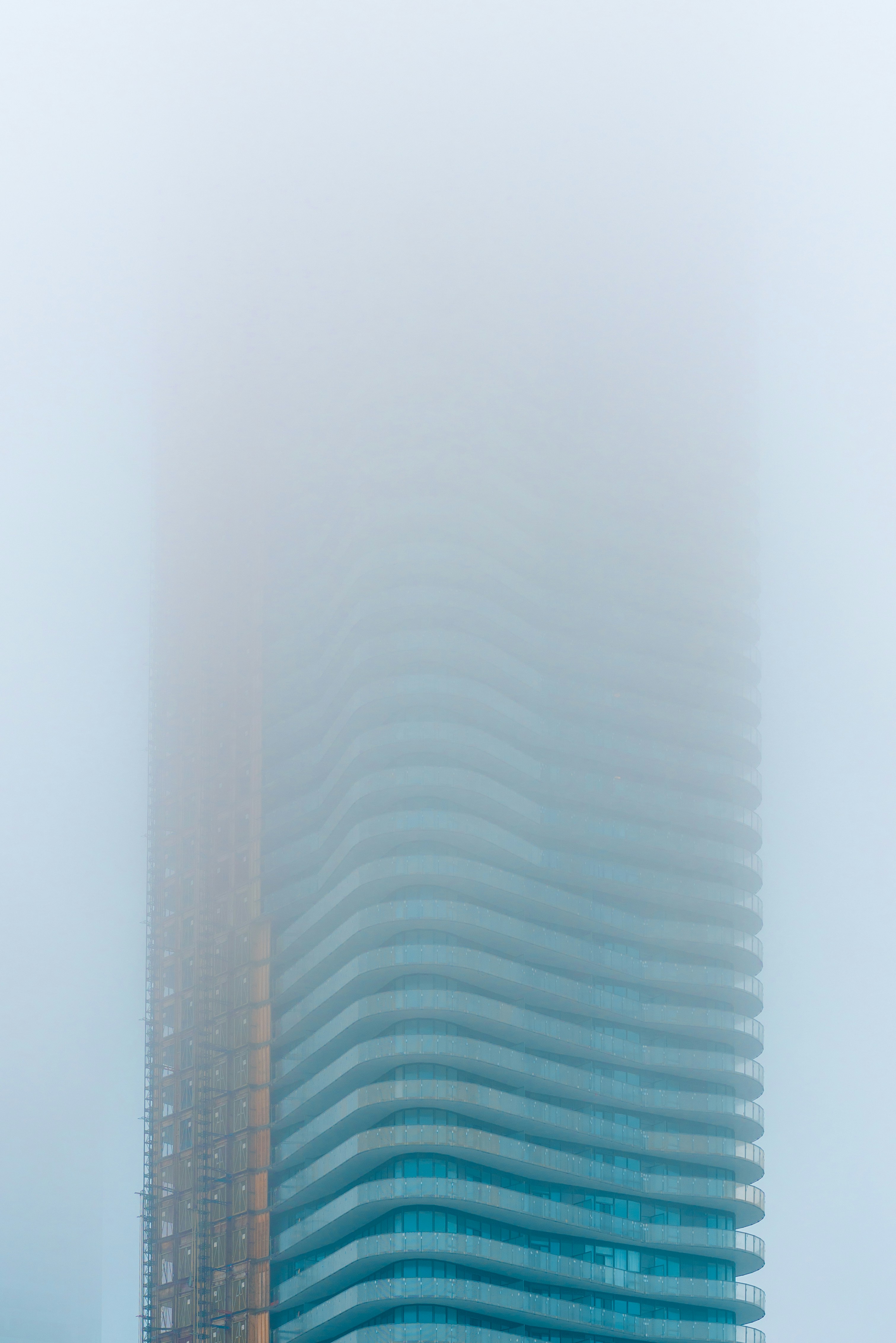 A building under construction in a foggy day.White.Rainforest ™︎ ∙ 易雨白林.
