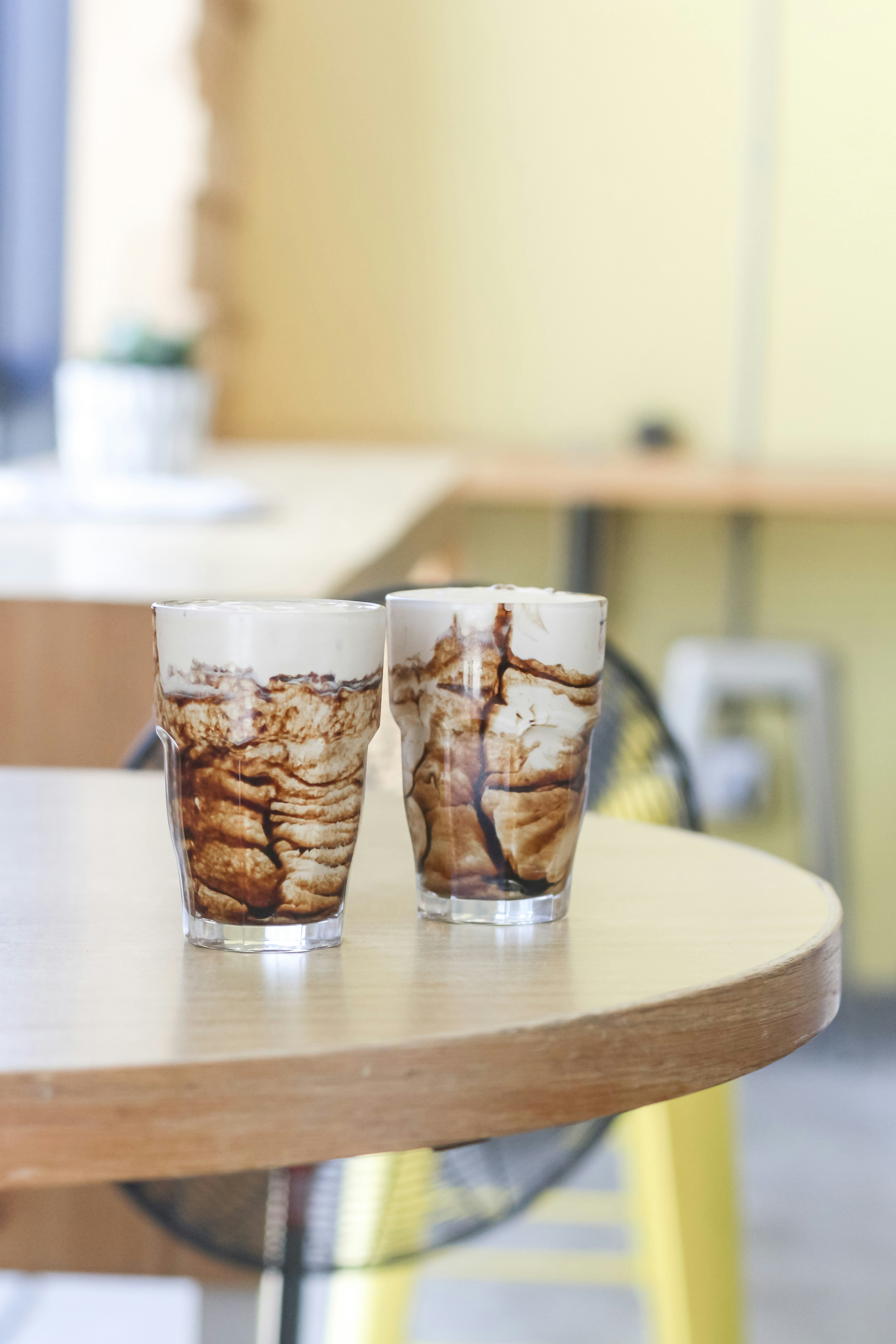 Twin Glasses on a Round Table: Chocolate Swirl Portrait in Soft Café Light