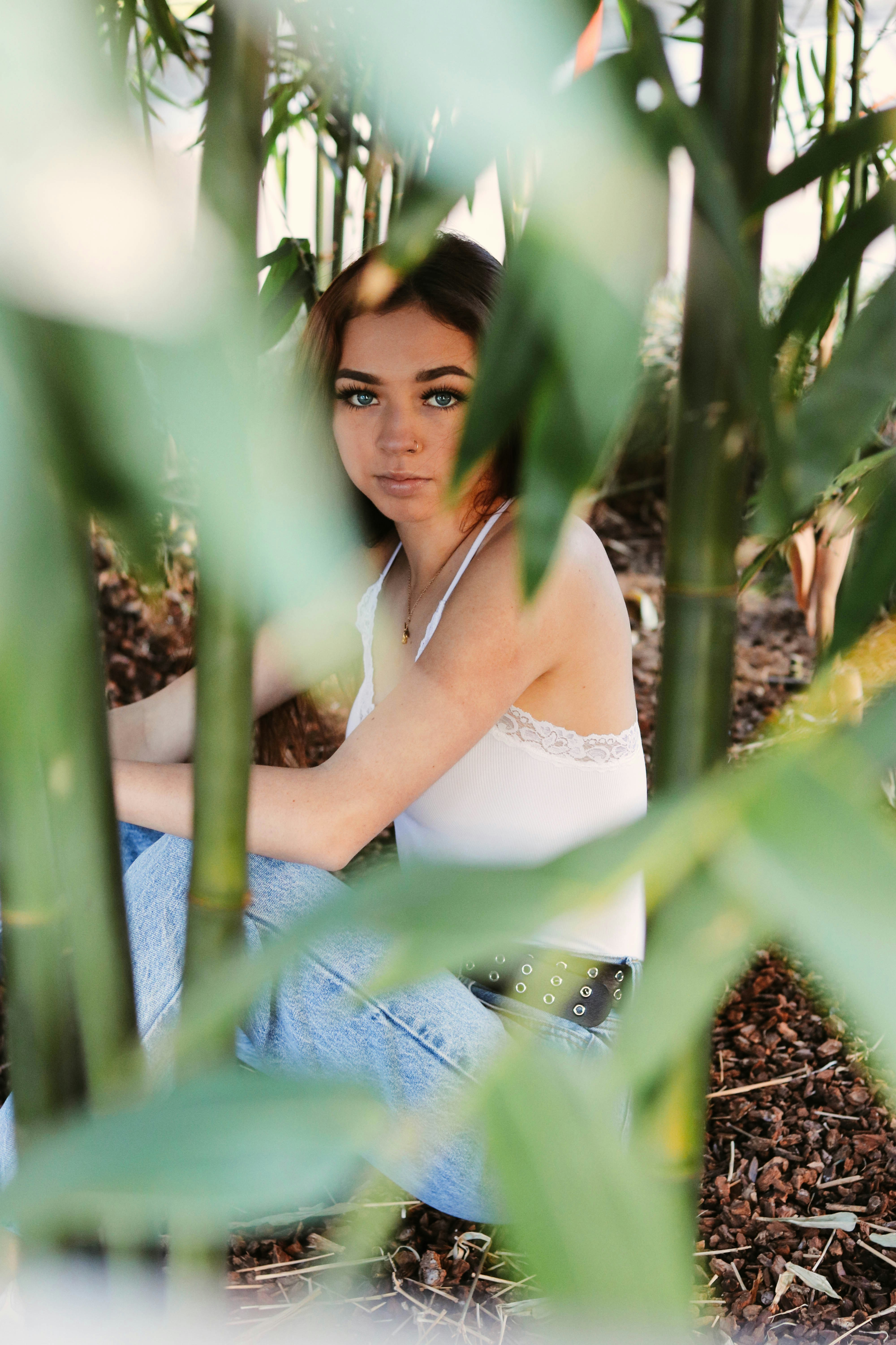 Gaze Through a Green Veil: Portrait Framed by Foliage