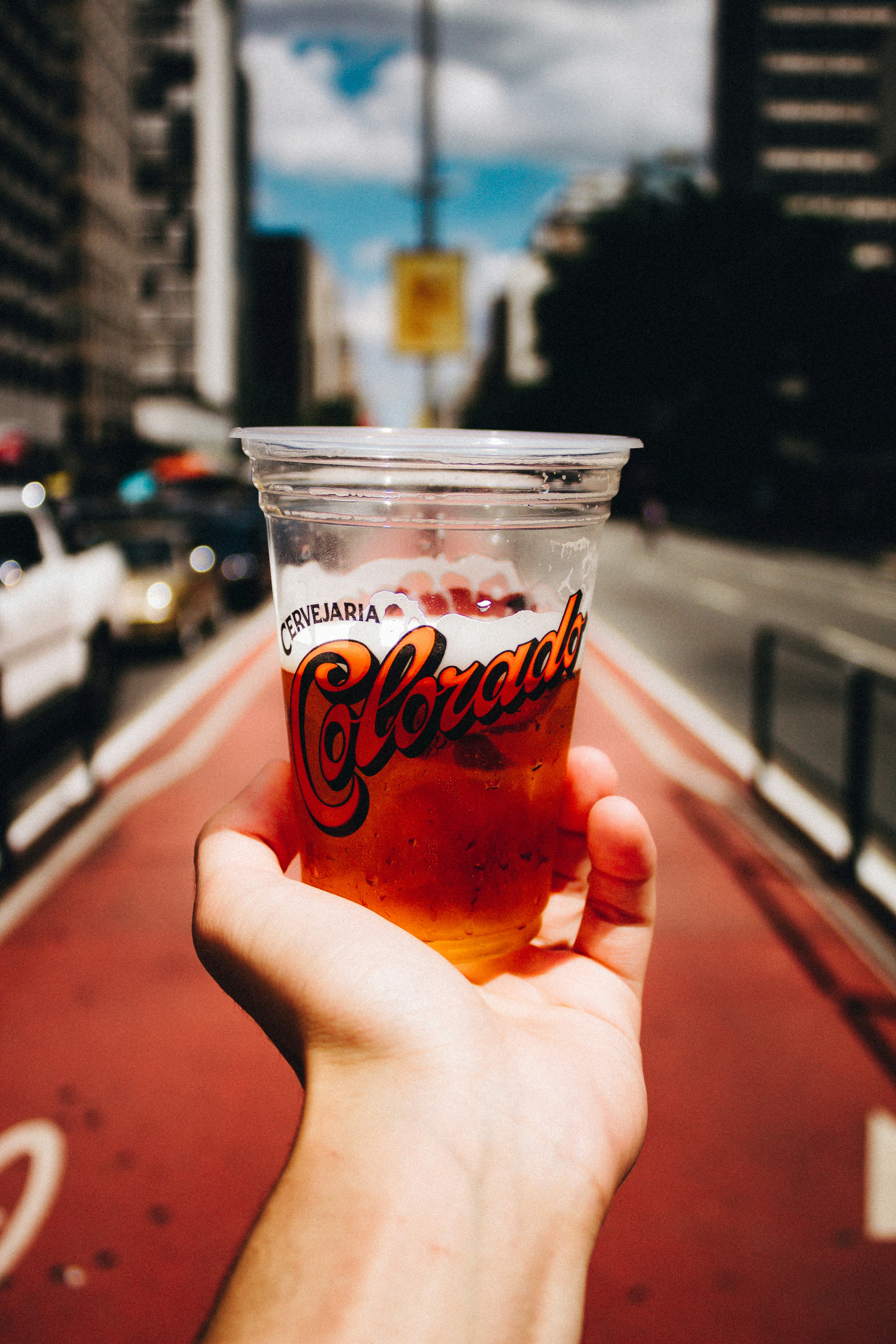 City Sip: A Hand-Held Cola Moment Amid Urban Traffic