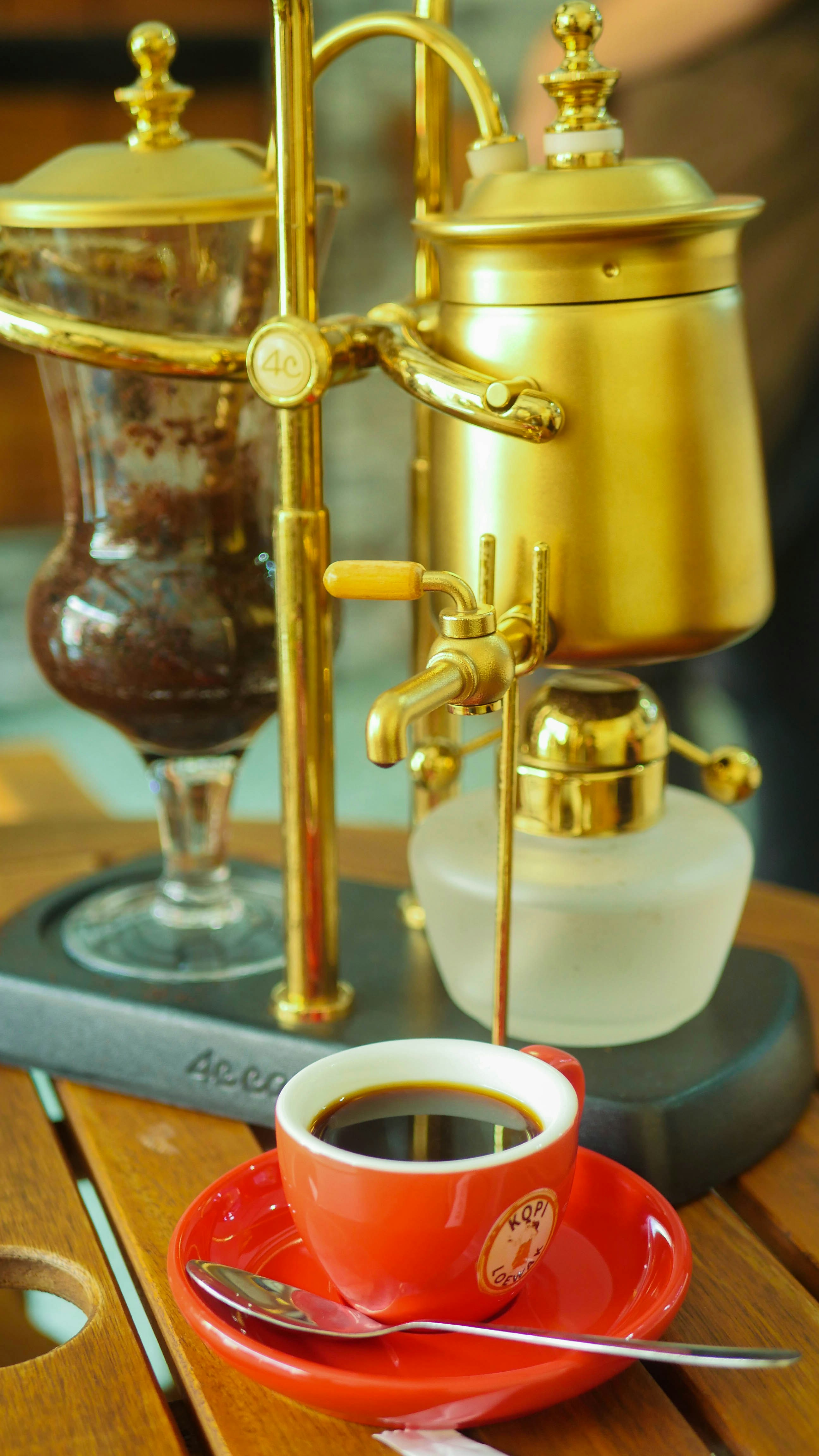 An old coffee machine with a red cup