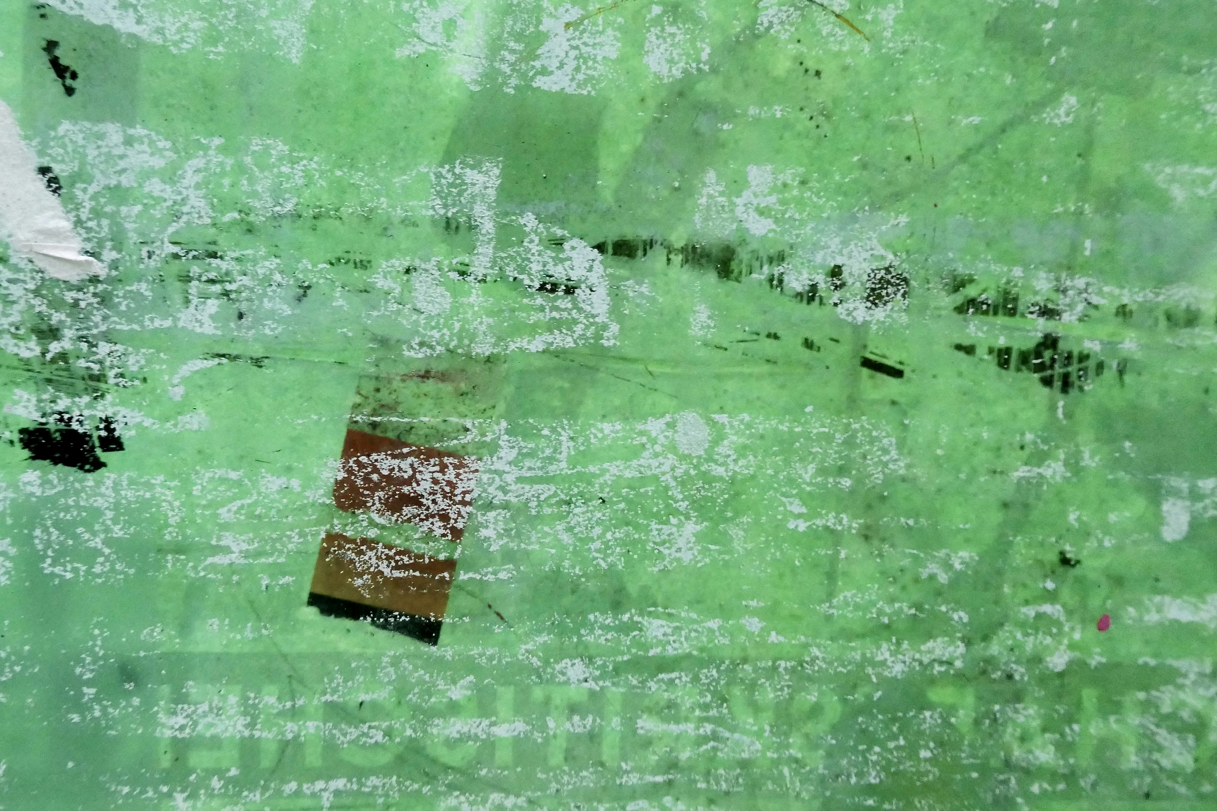 Abstract composition featuring layers of green hues with subtle textures and elements of color. The interplay of materials creates a dynamic visual experience.