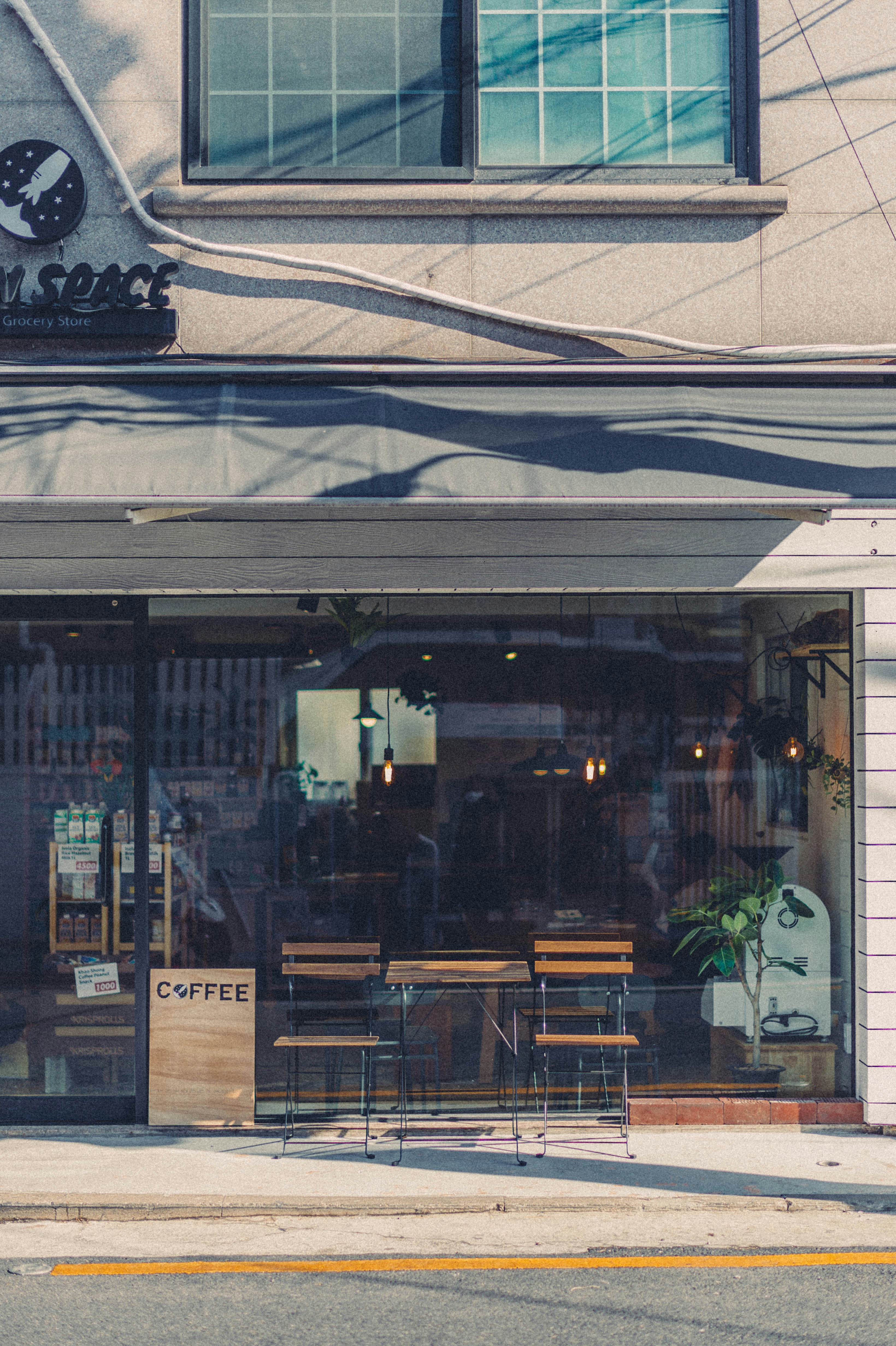 Brown wooden chairs and tables in front of glass window photo – Free ...