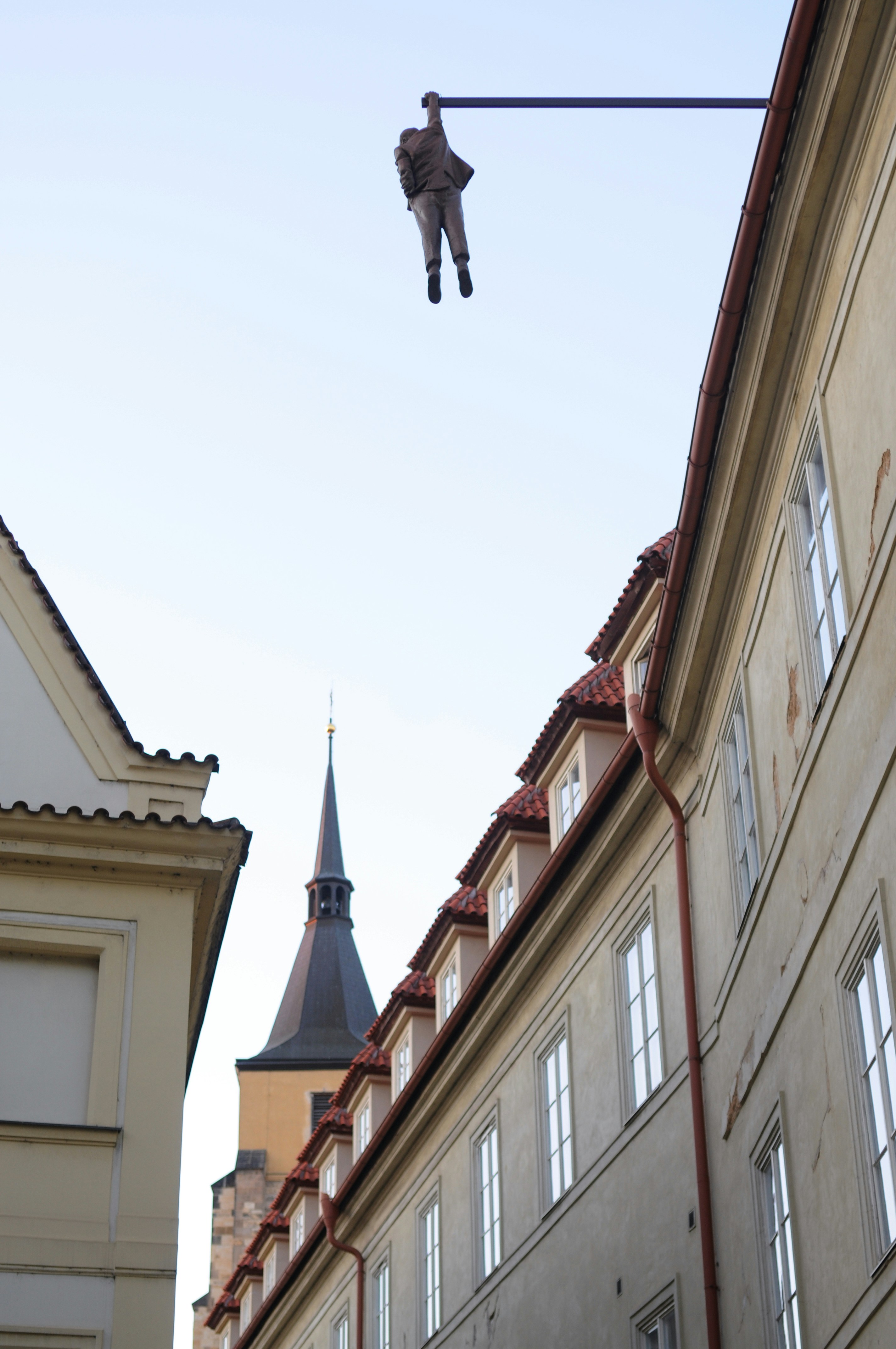 Suspended in the Sky: A lone climber dangles between sunlit European façades