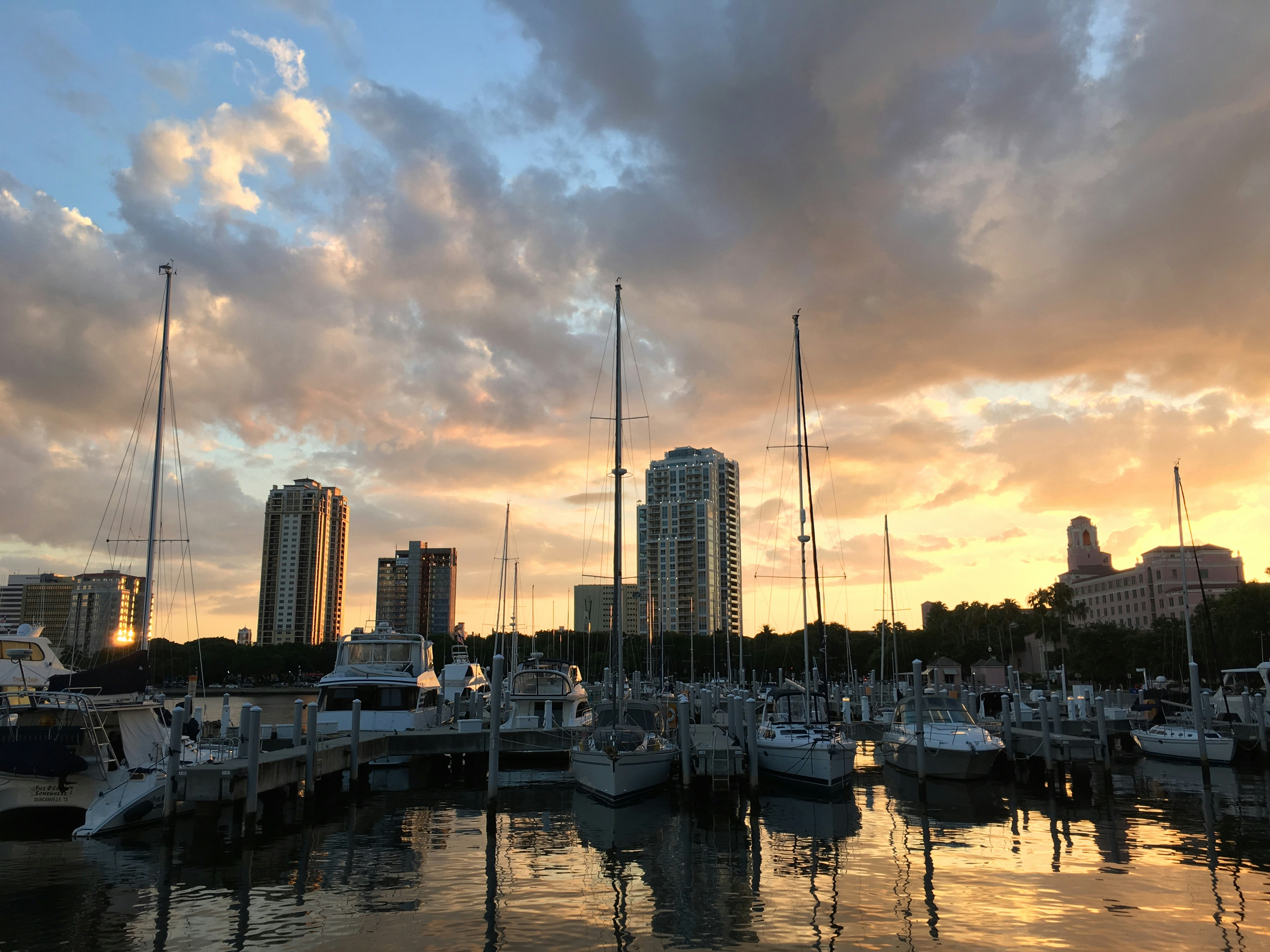 a harbor filled with lots of boats under a cloudy sky