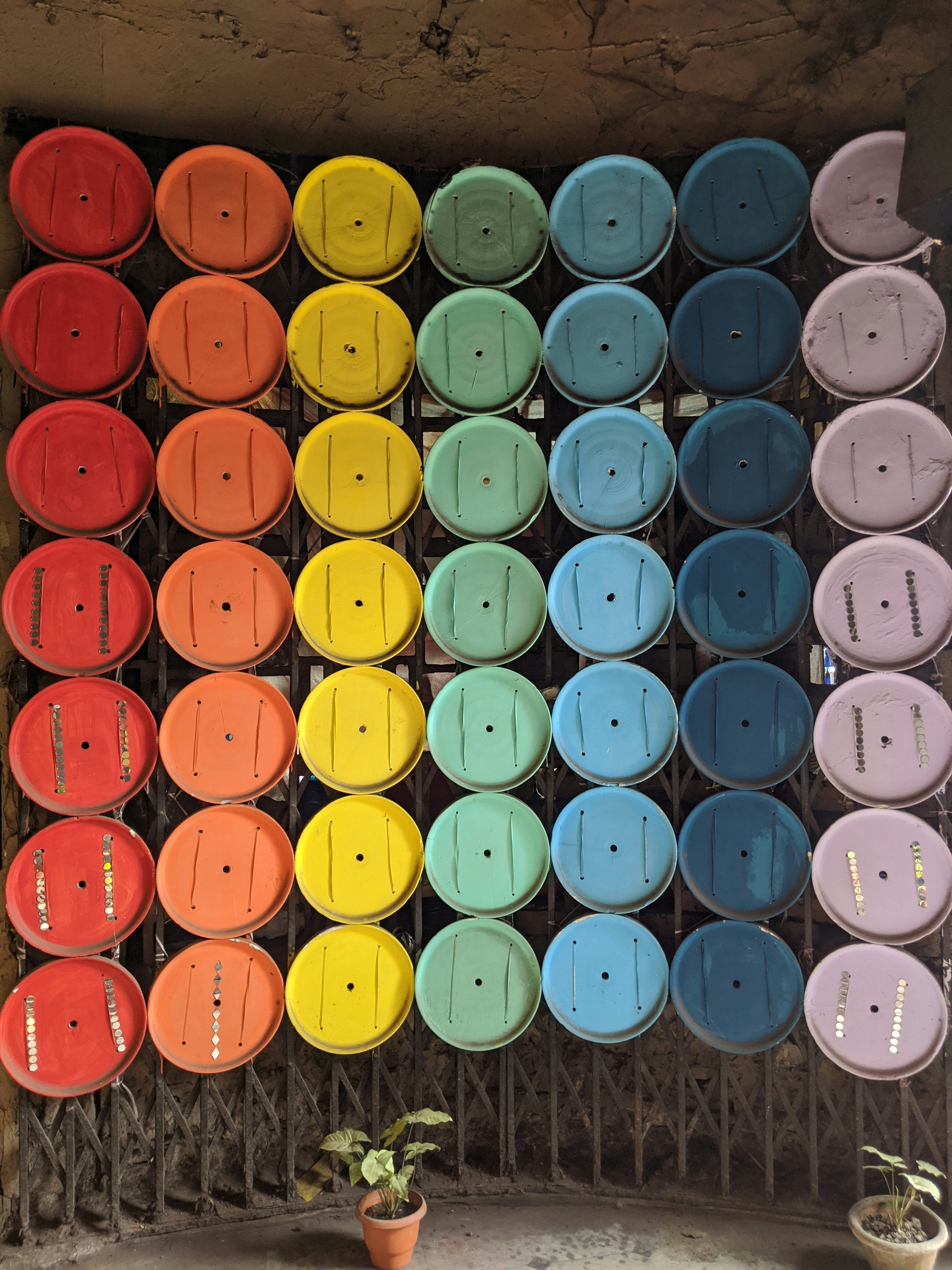 Rainbow Barrels: A Wall of Colorful Caps Line the Ground