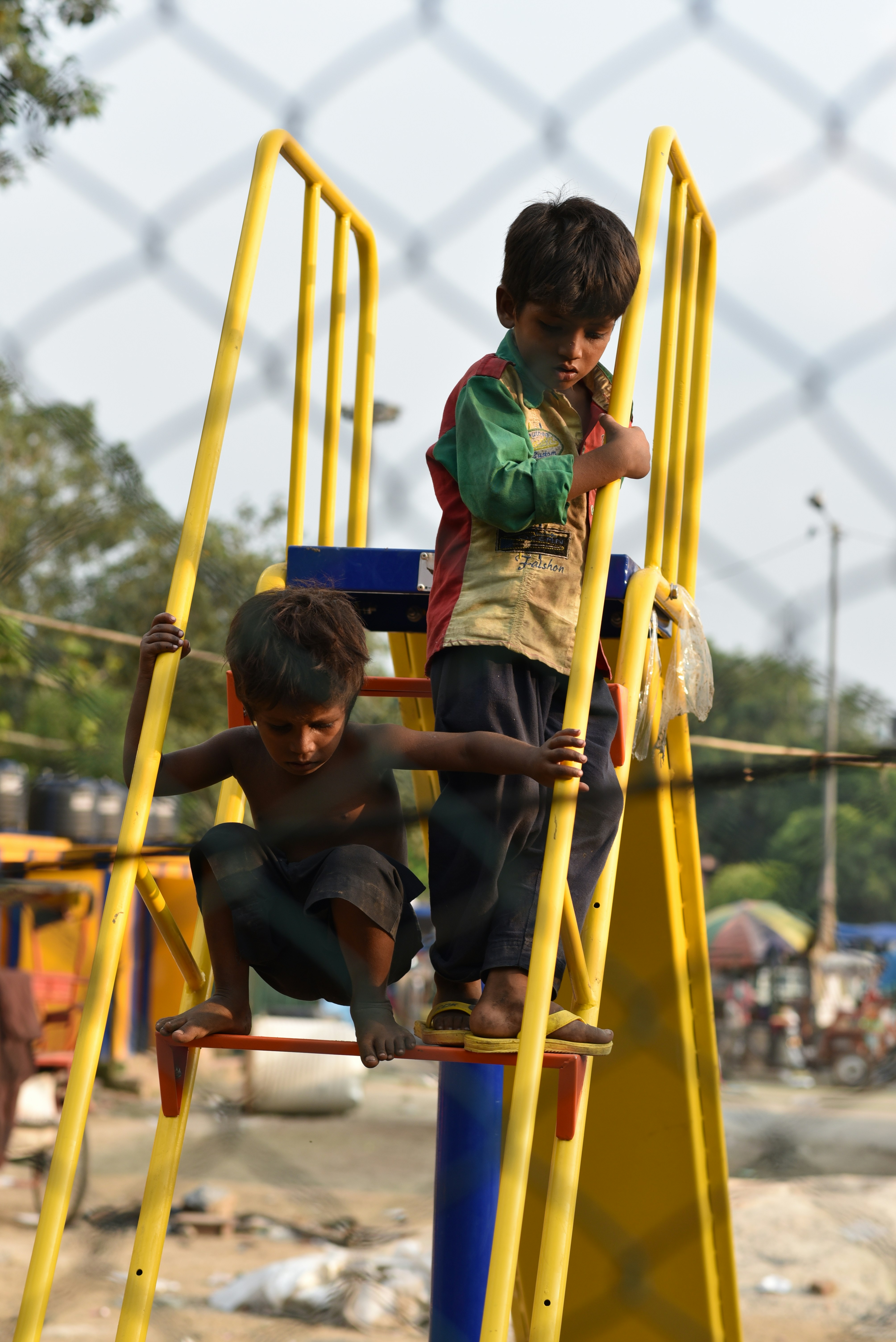 Yellow Rails, Quiet Focus: Boys on a Sunlit Playground Tower