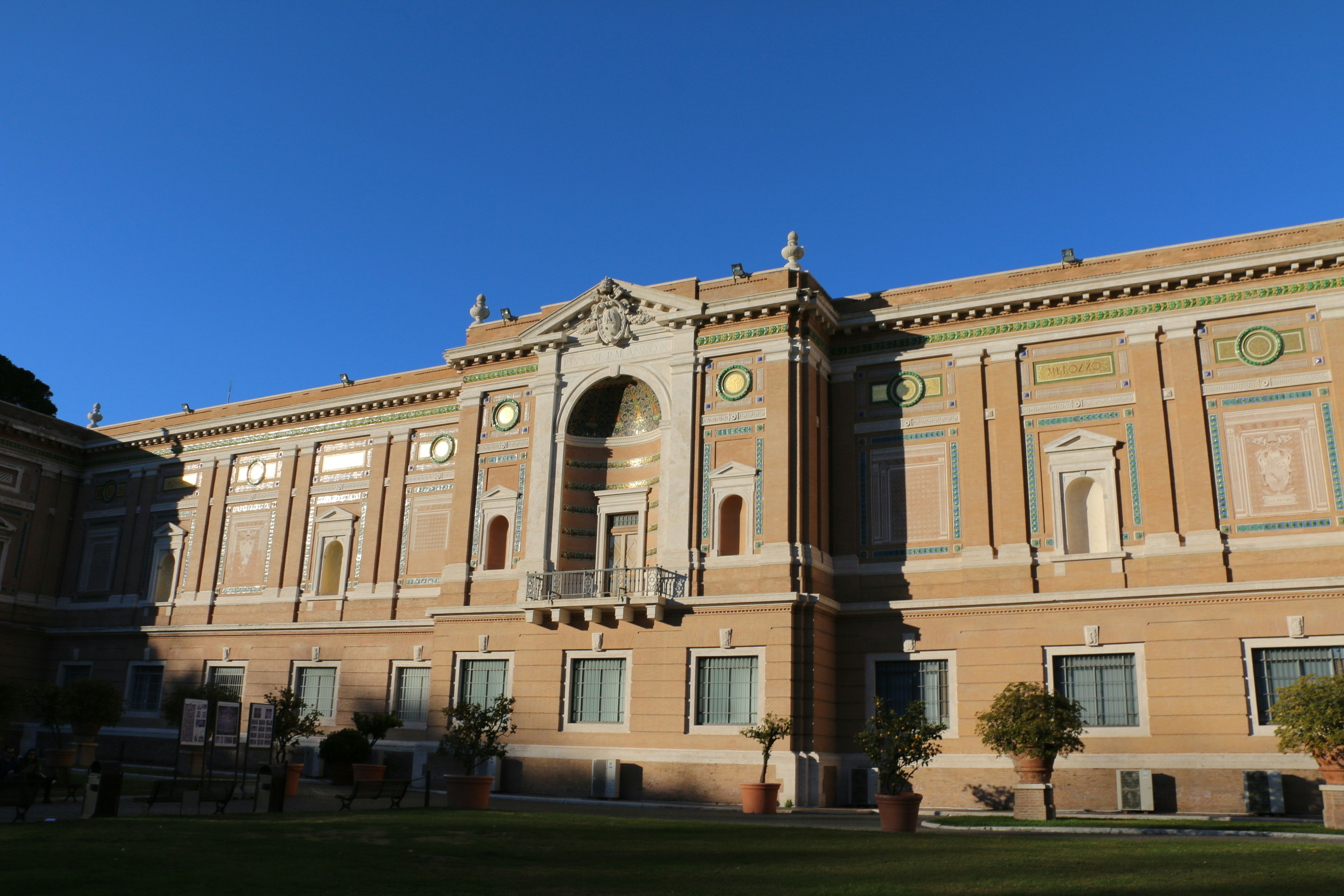 Elegant façade of a historic building illuminated by the warm glow of late afternoon sun, showcasing intricate architectural details.