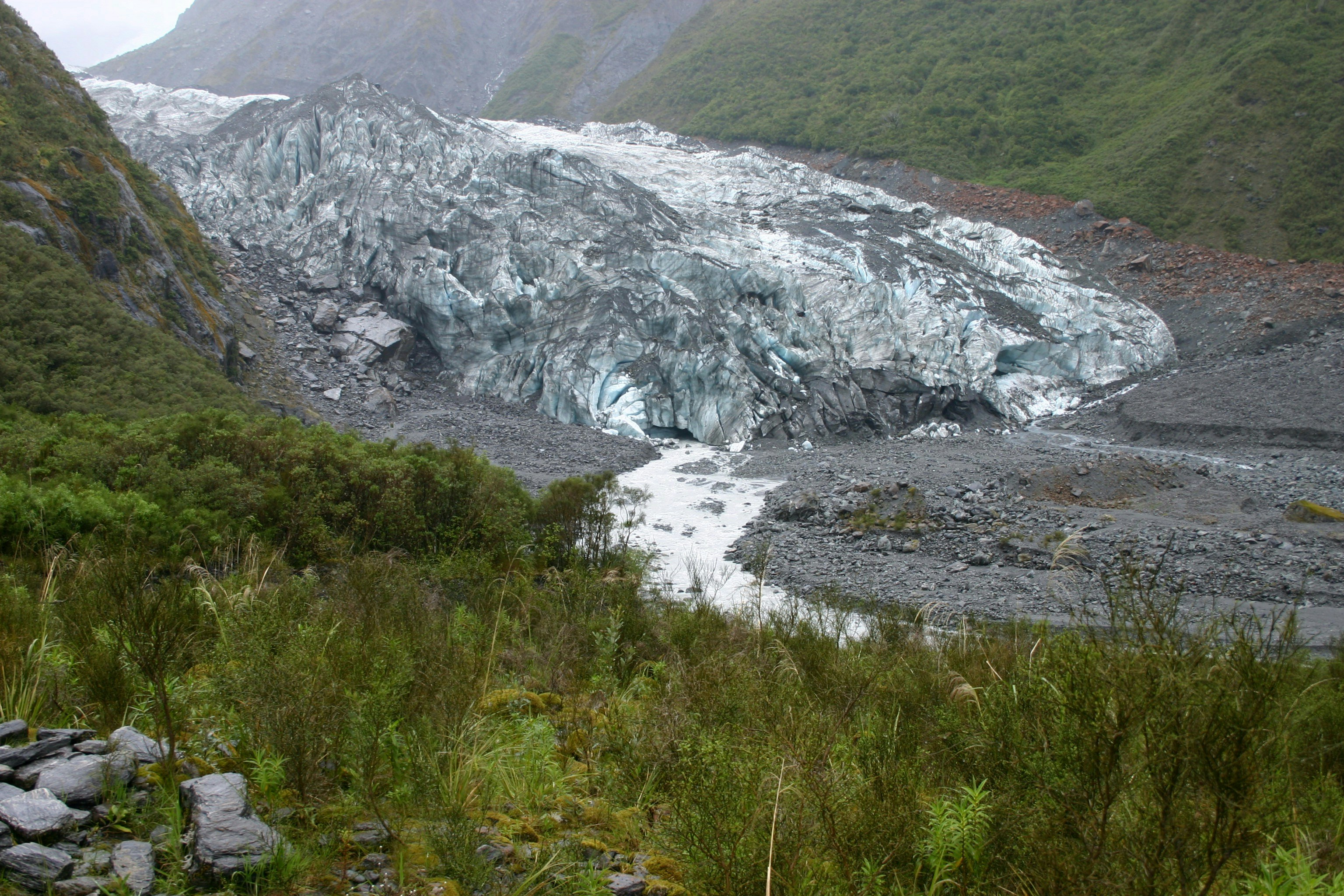 Blue Ice Vein Winding Through a Verdant Valley