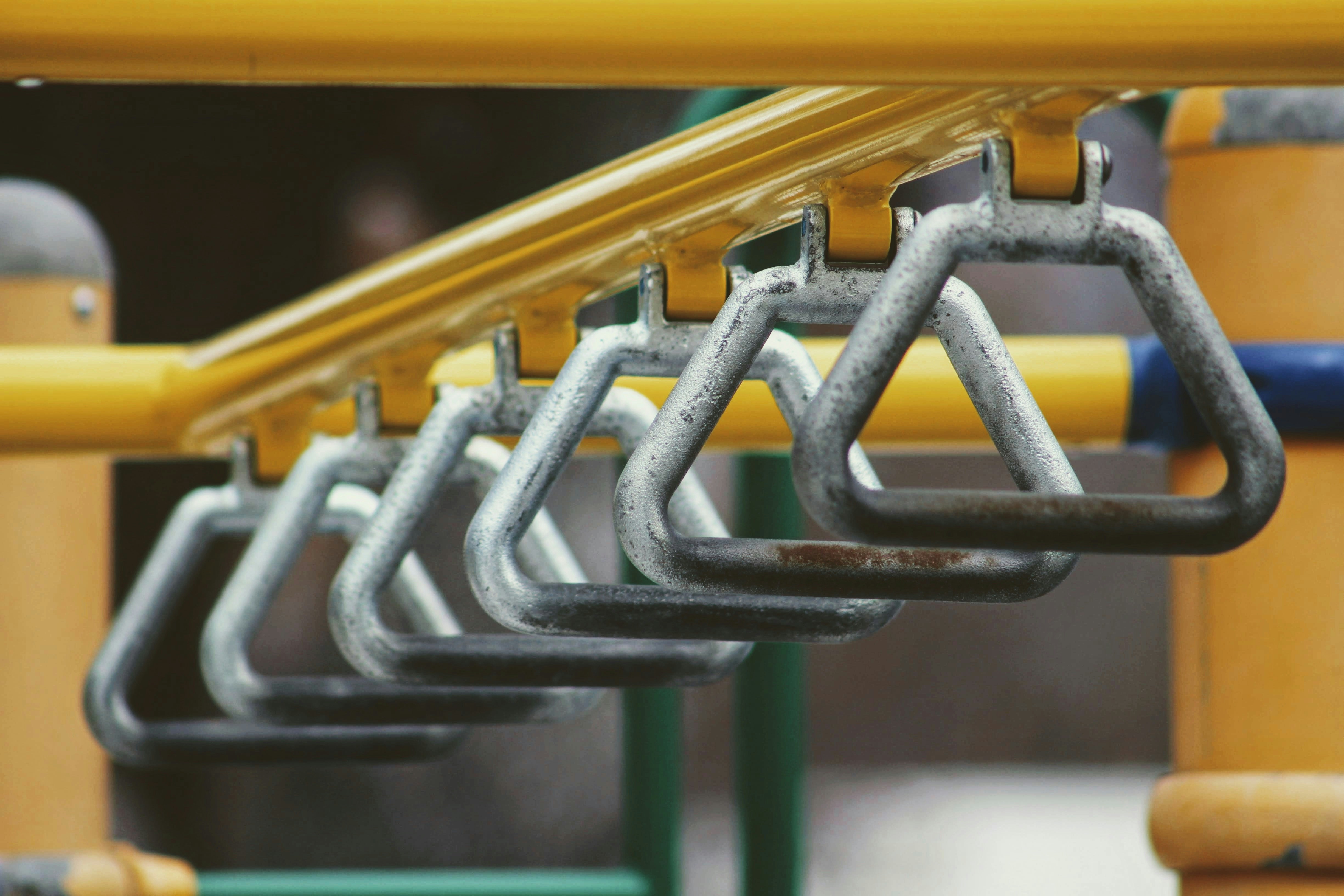 Close-up of a series of metallic hand grips on a playground structure, showcasing vibrant colors and textures.
