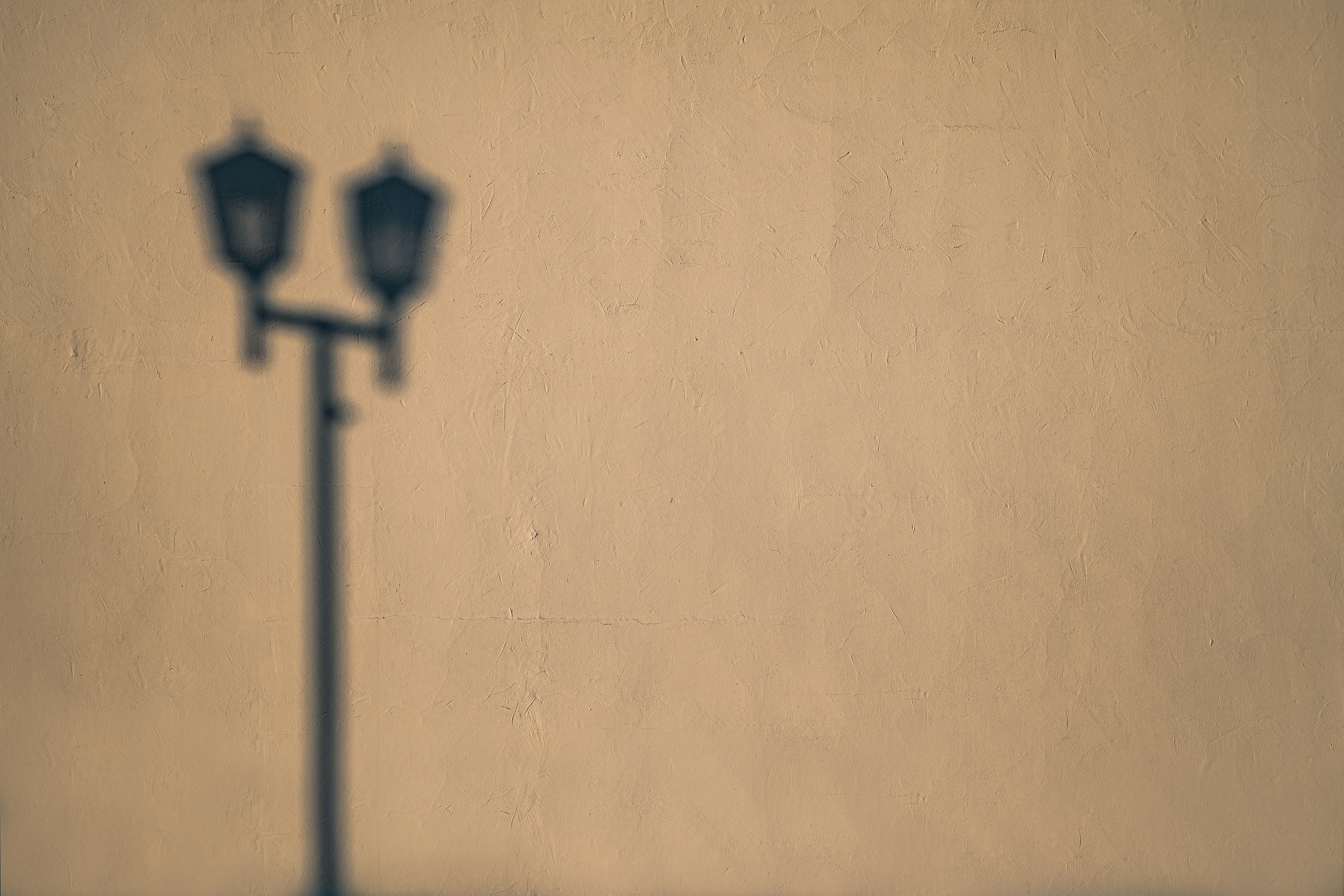 Shadowed Lantern Post on a Blurred Wall