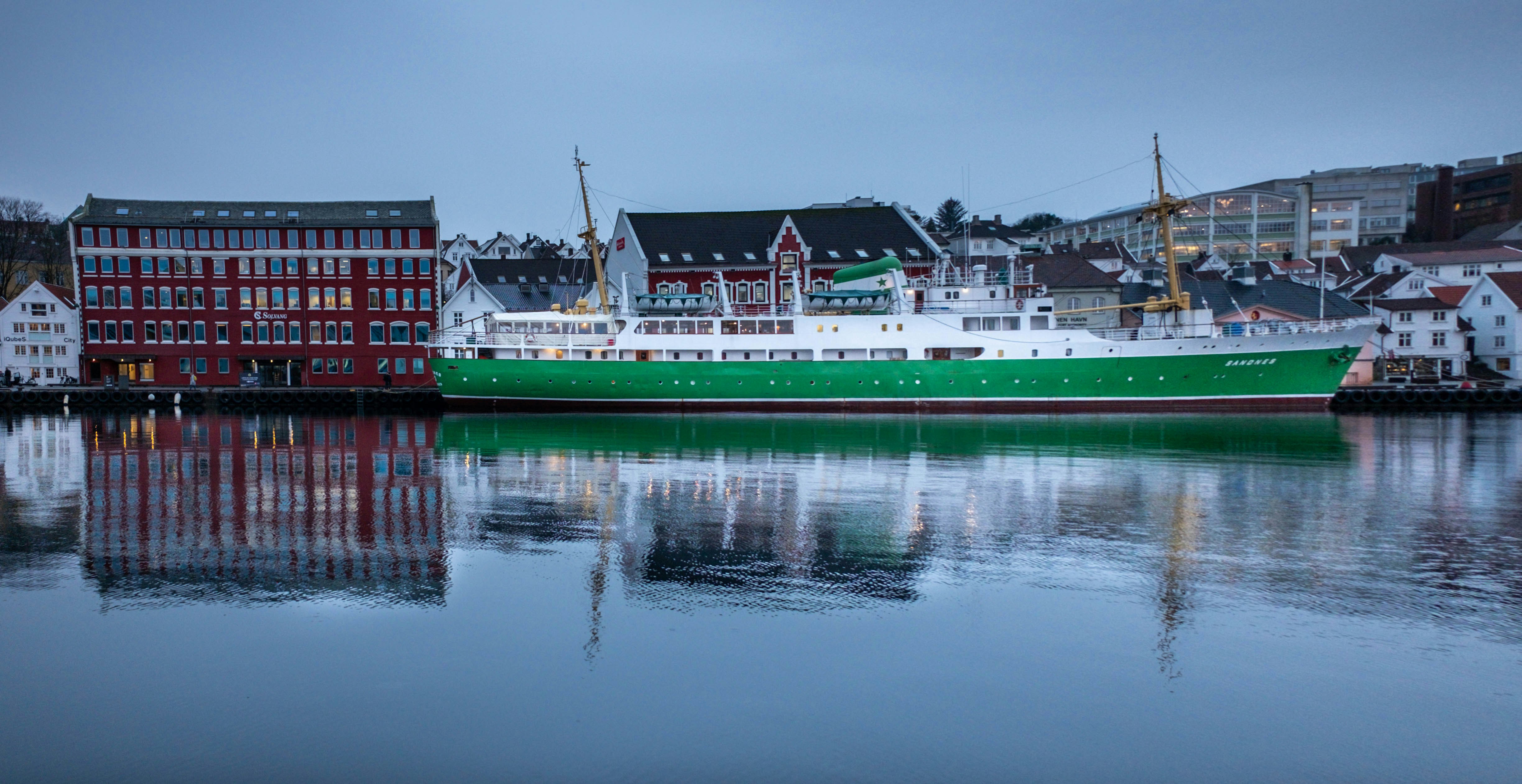 Emerald-Hulled Vessel Anchored in a Mirror Harbor