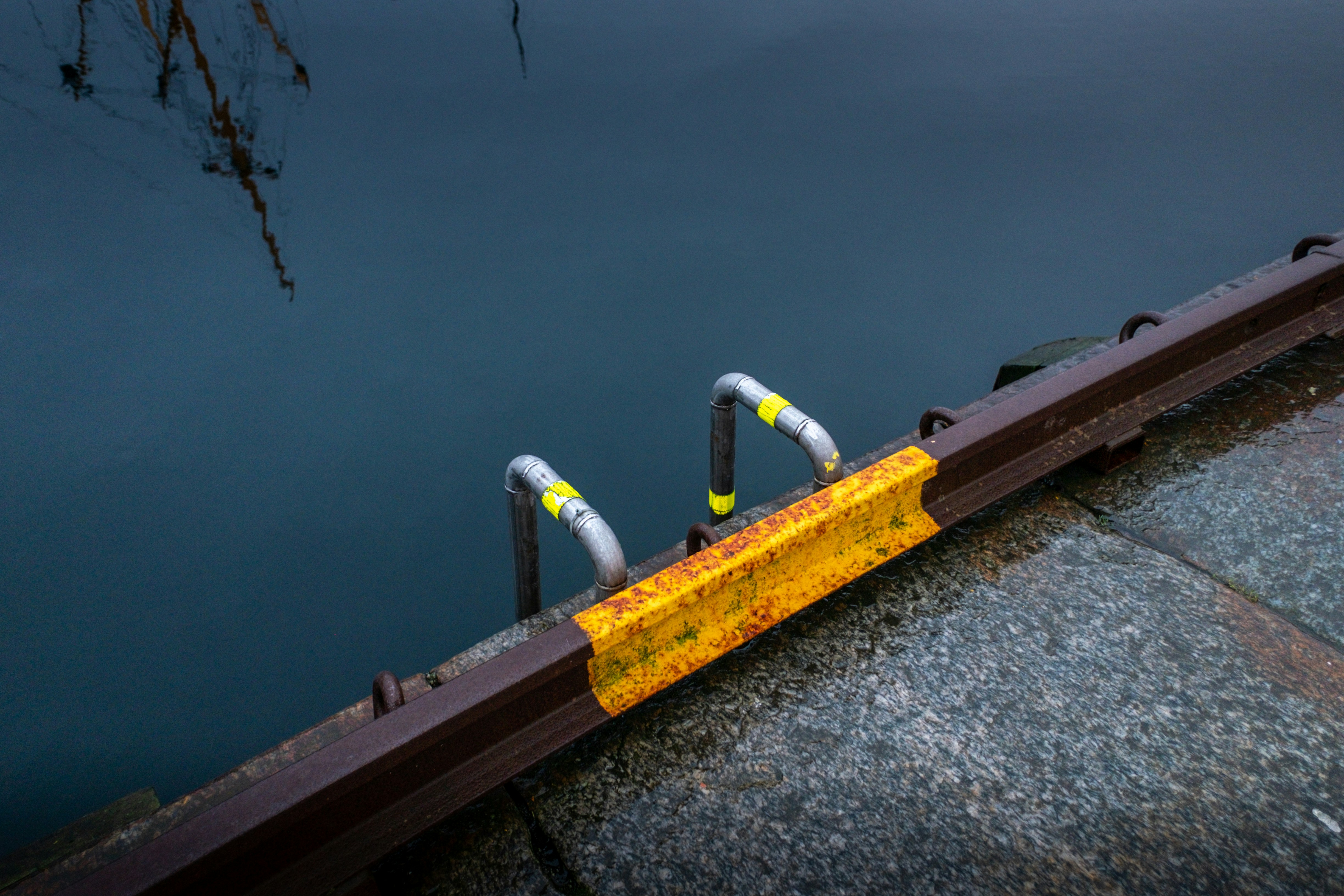 yellow and black metal bar on brown wooden dock