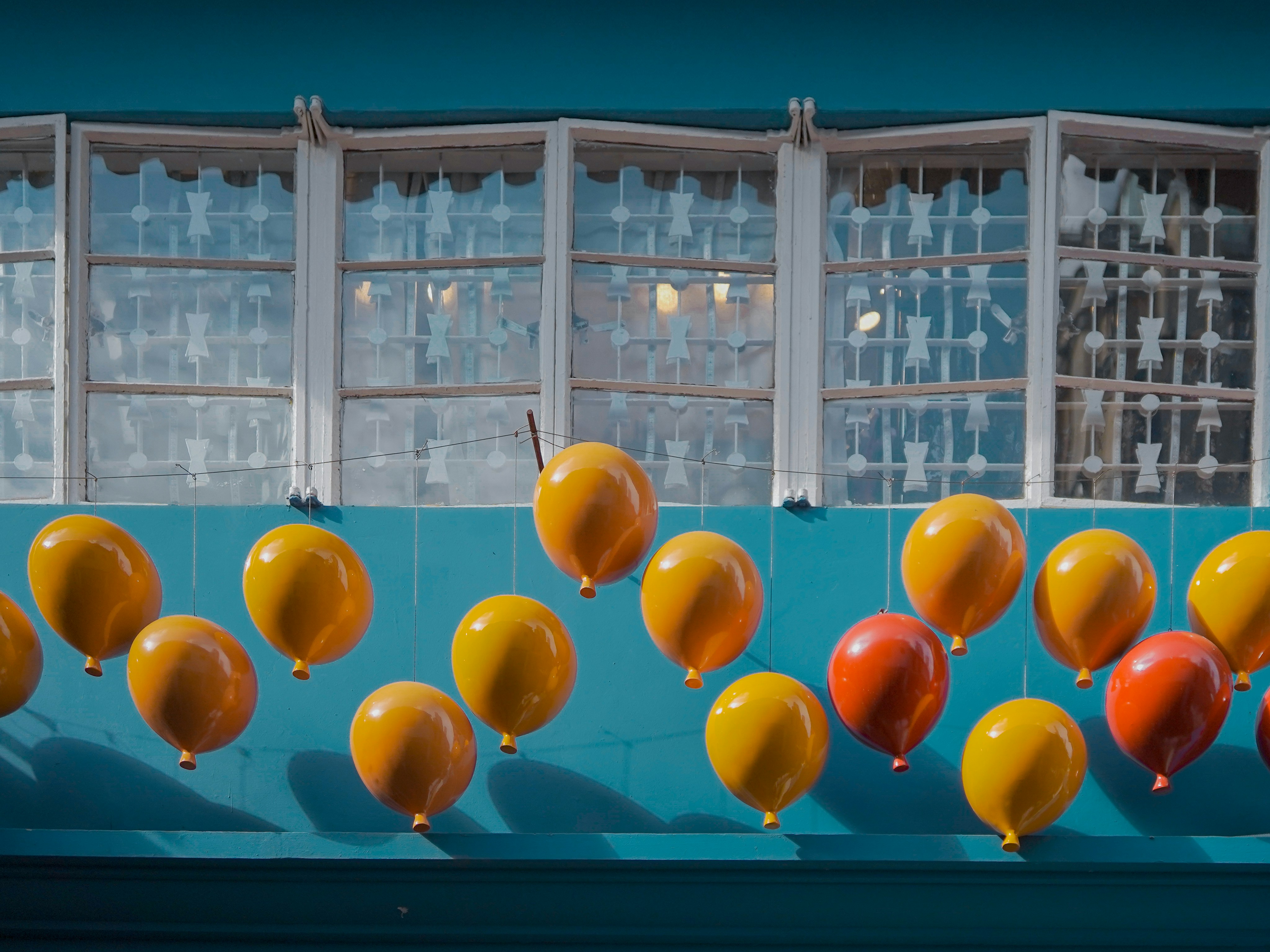 Yellow red and blue balloons on white metal frame glass window photo ...