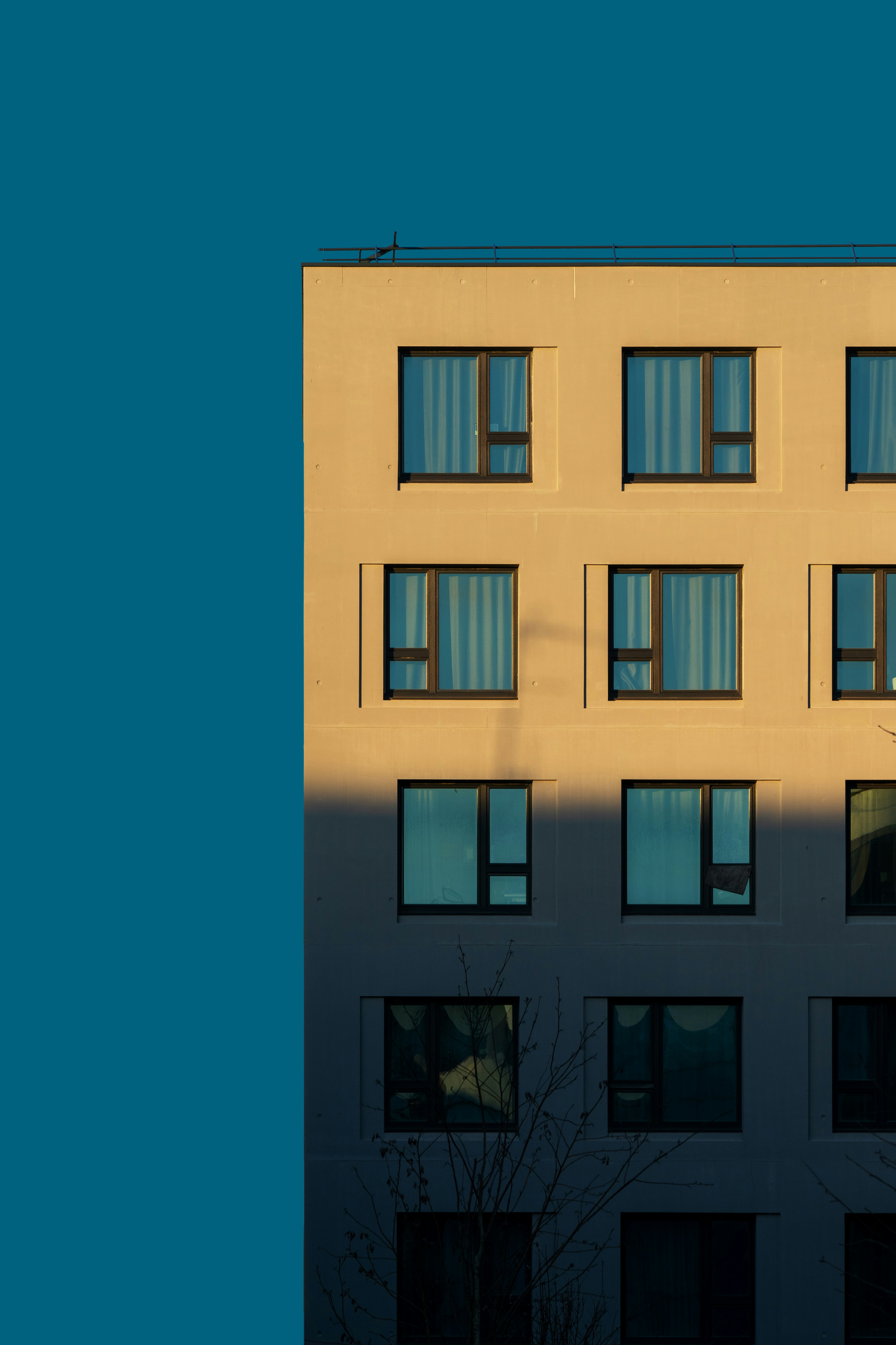 Sunlit Facade Grid Against a Teal Backdrop