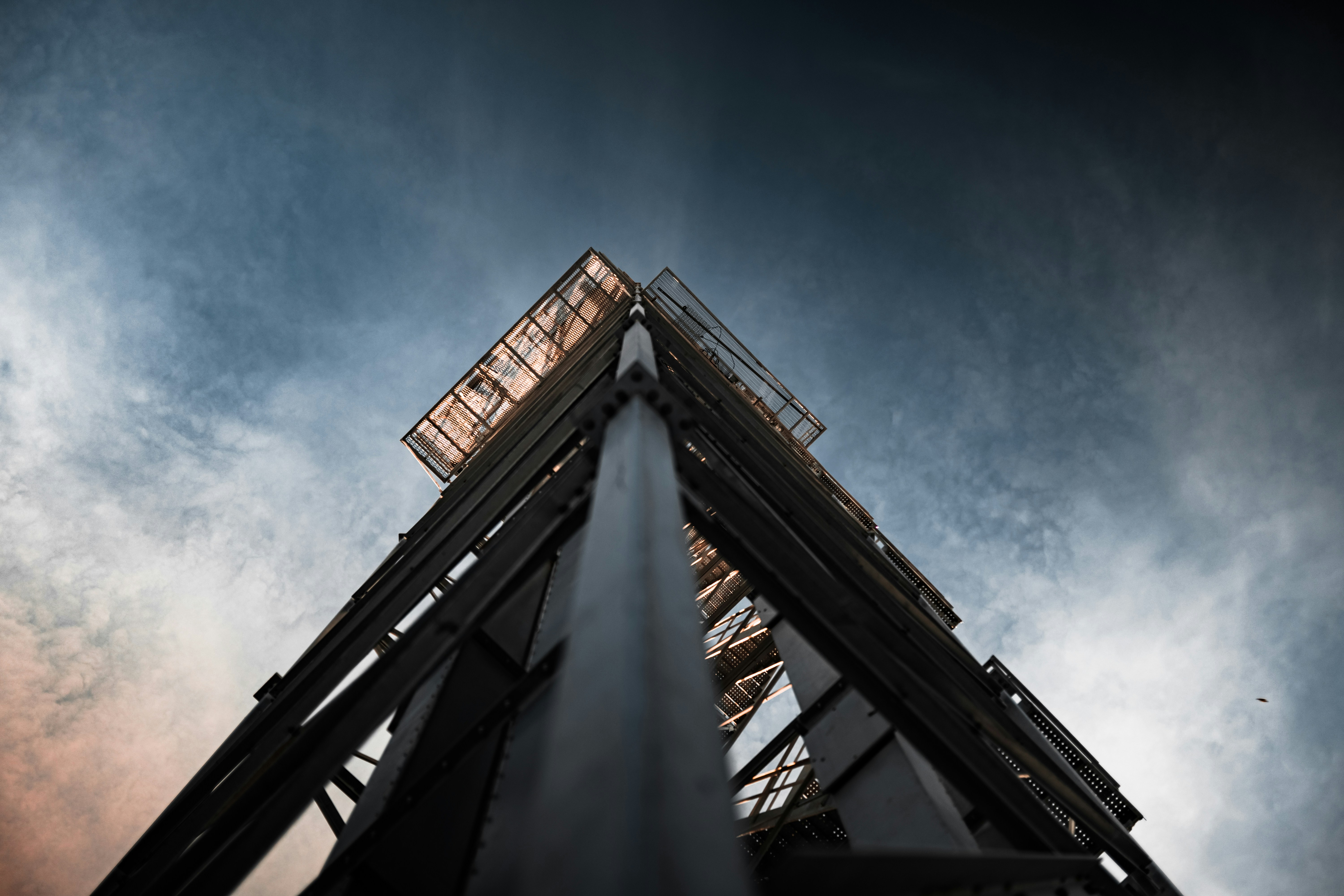 Steel tower reaching skyward, framed by a dramatic sky transitioning from dusk to night.