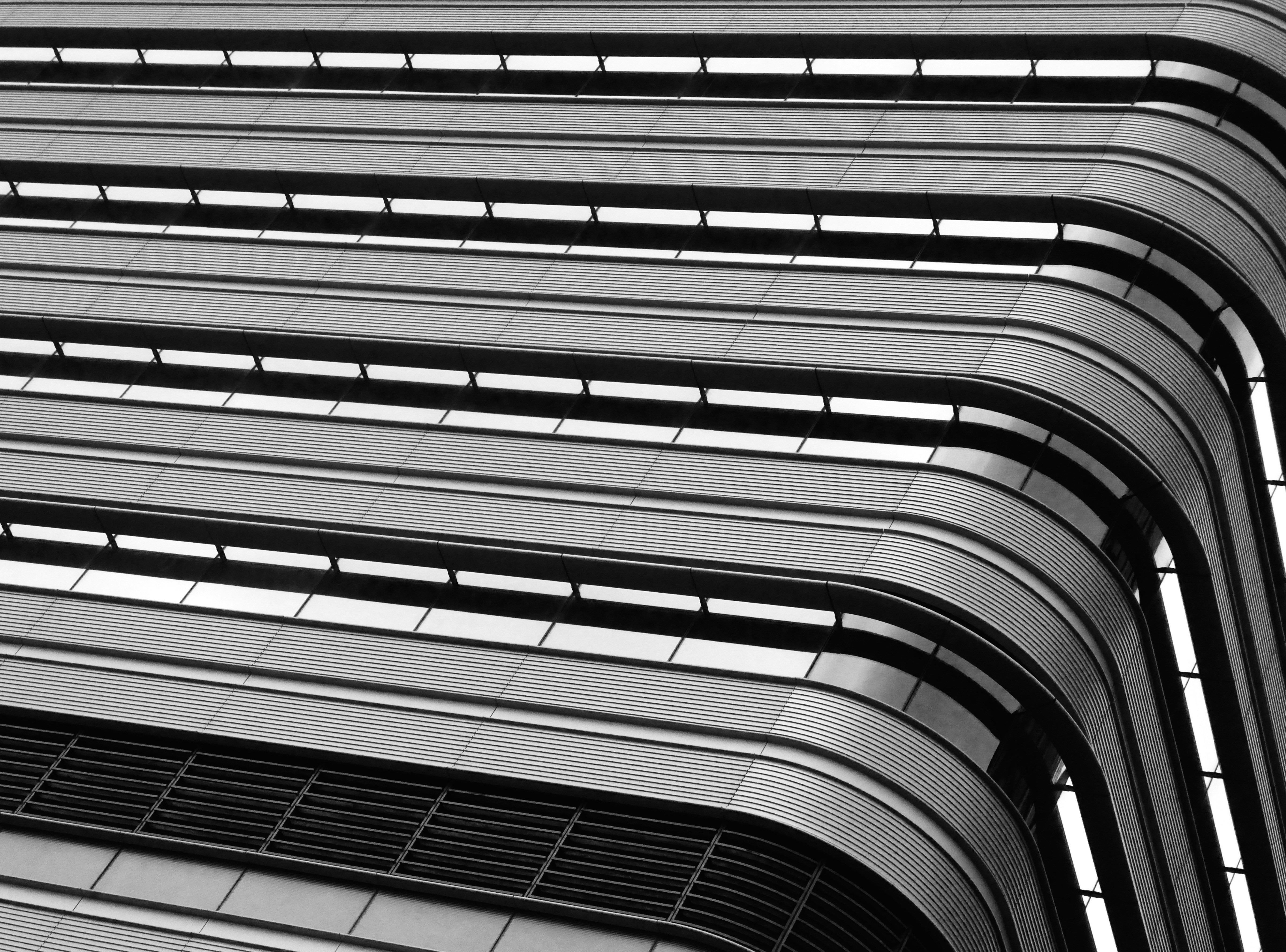 Abstract representation of a contemporary building's curved lines and textures in black and white.