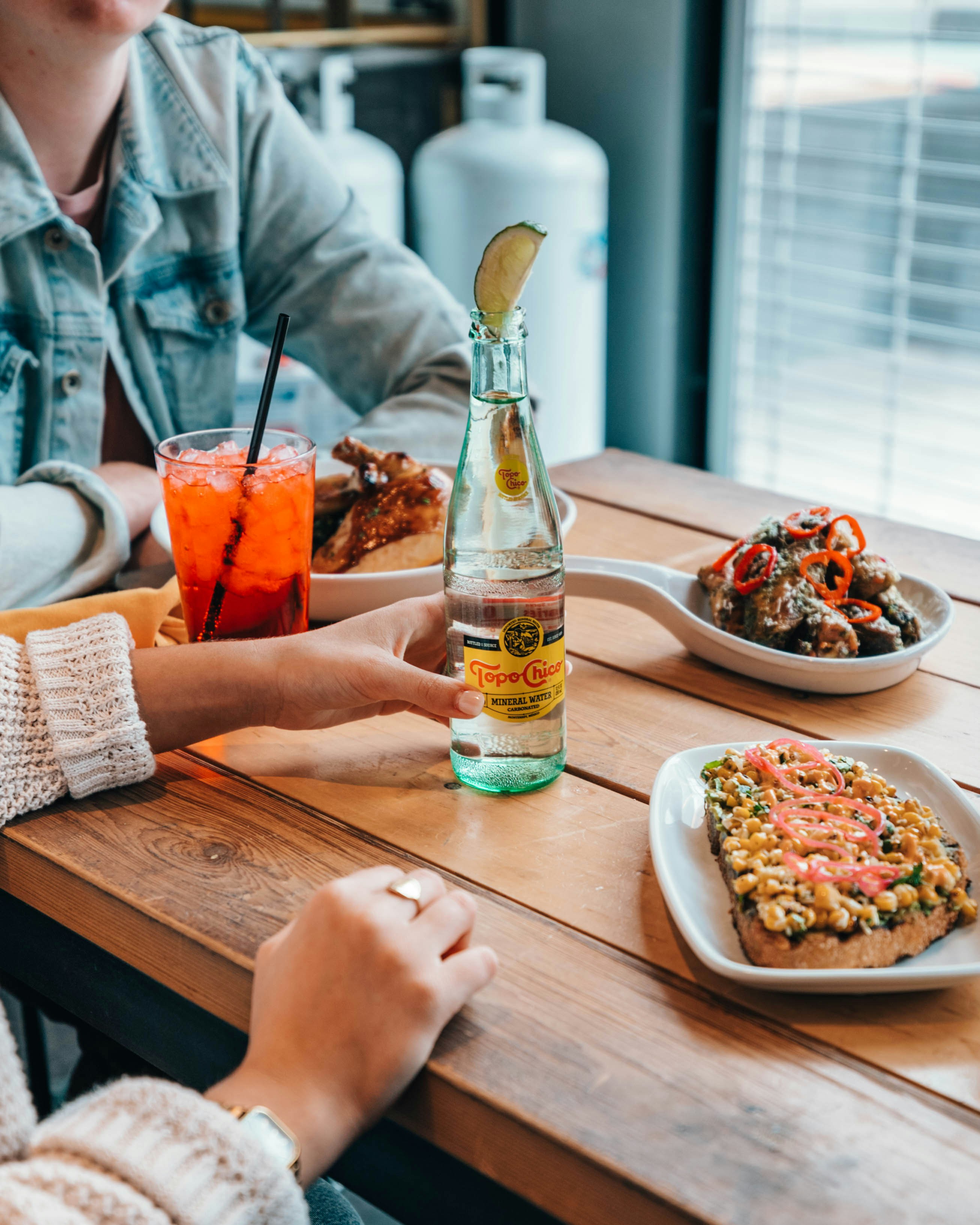 person holding fork and knife slicing food on brown wooden table
