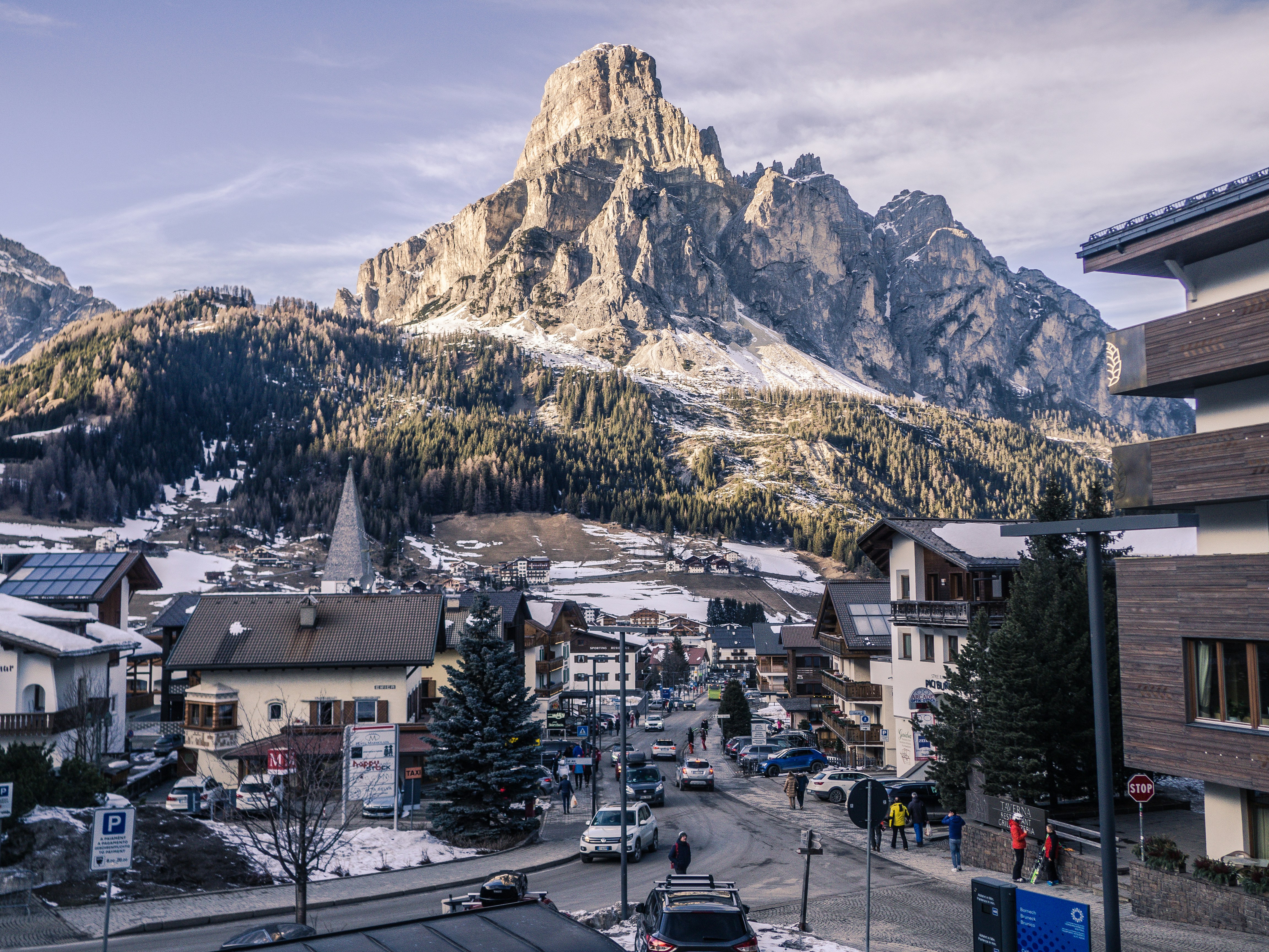 Snow-dusted village with towering mountain backdrop and clear skies.
