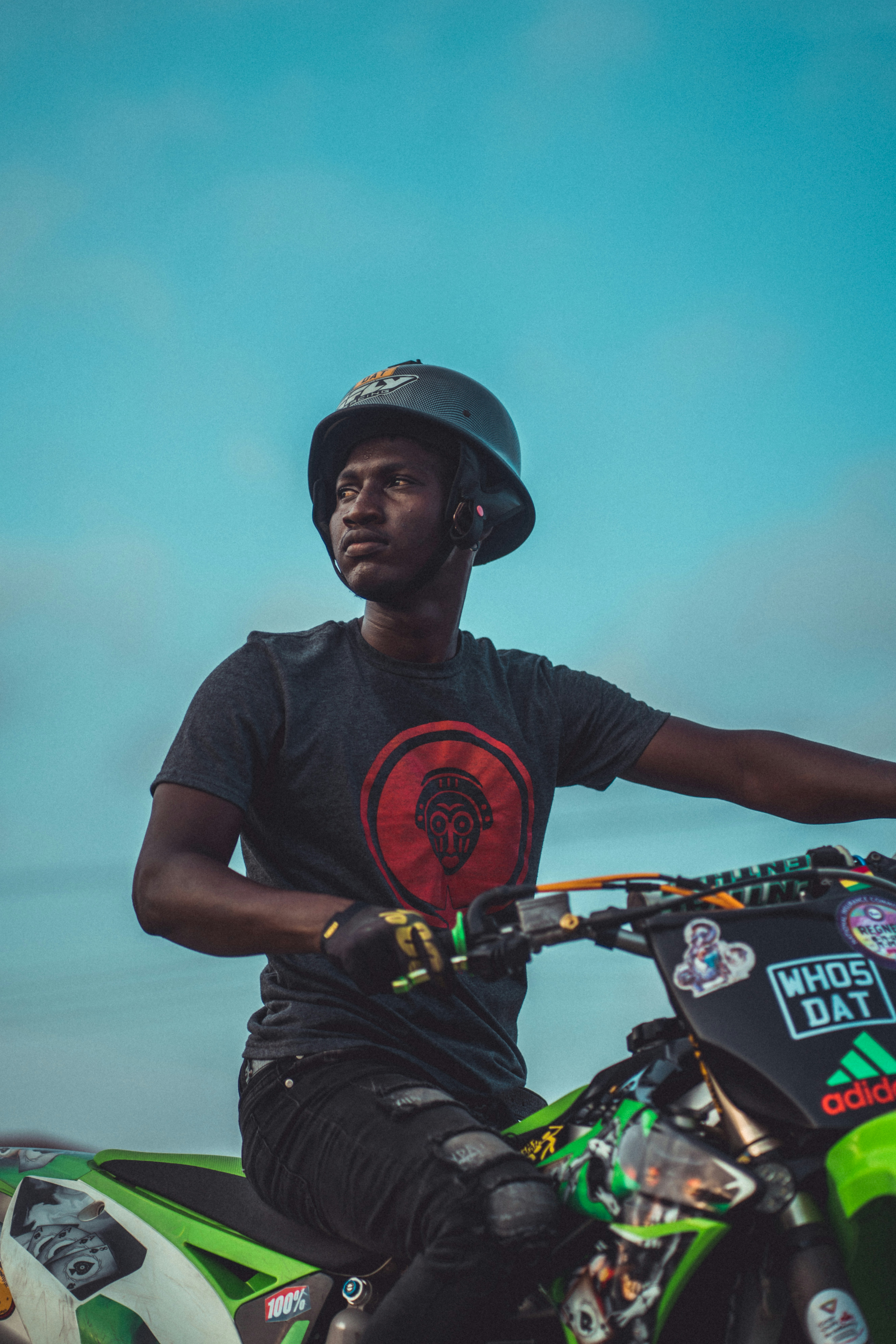 Cerulean Sky, Neon Green: Portrait of a Helmeted Dirt-Biker in Motion