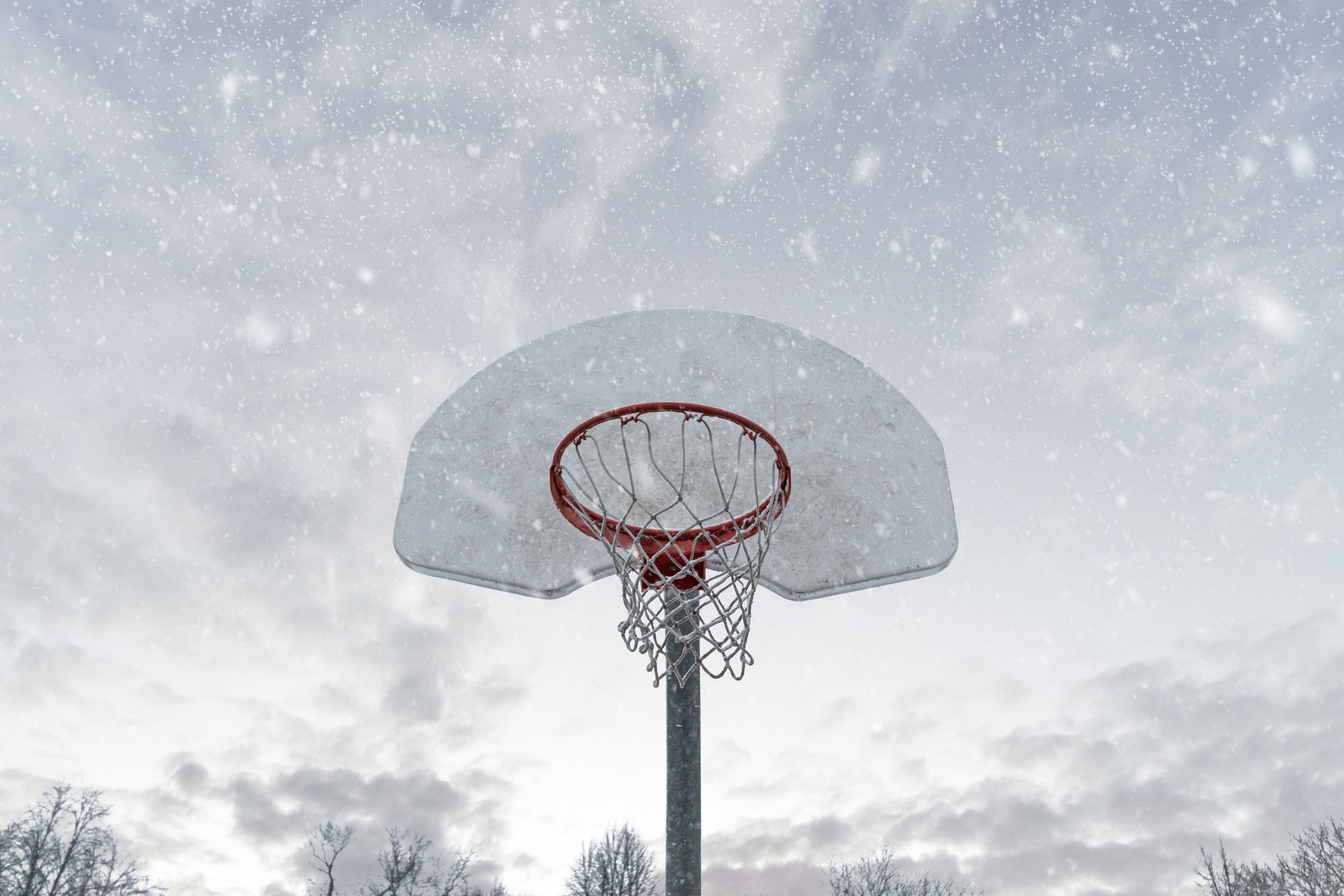 red and black basketball hoop under white clouds
