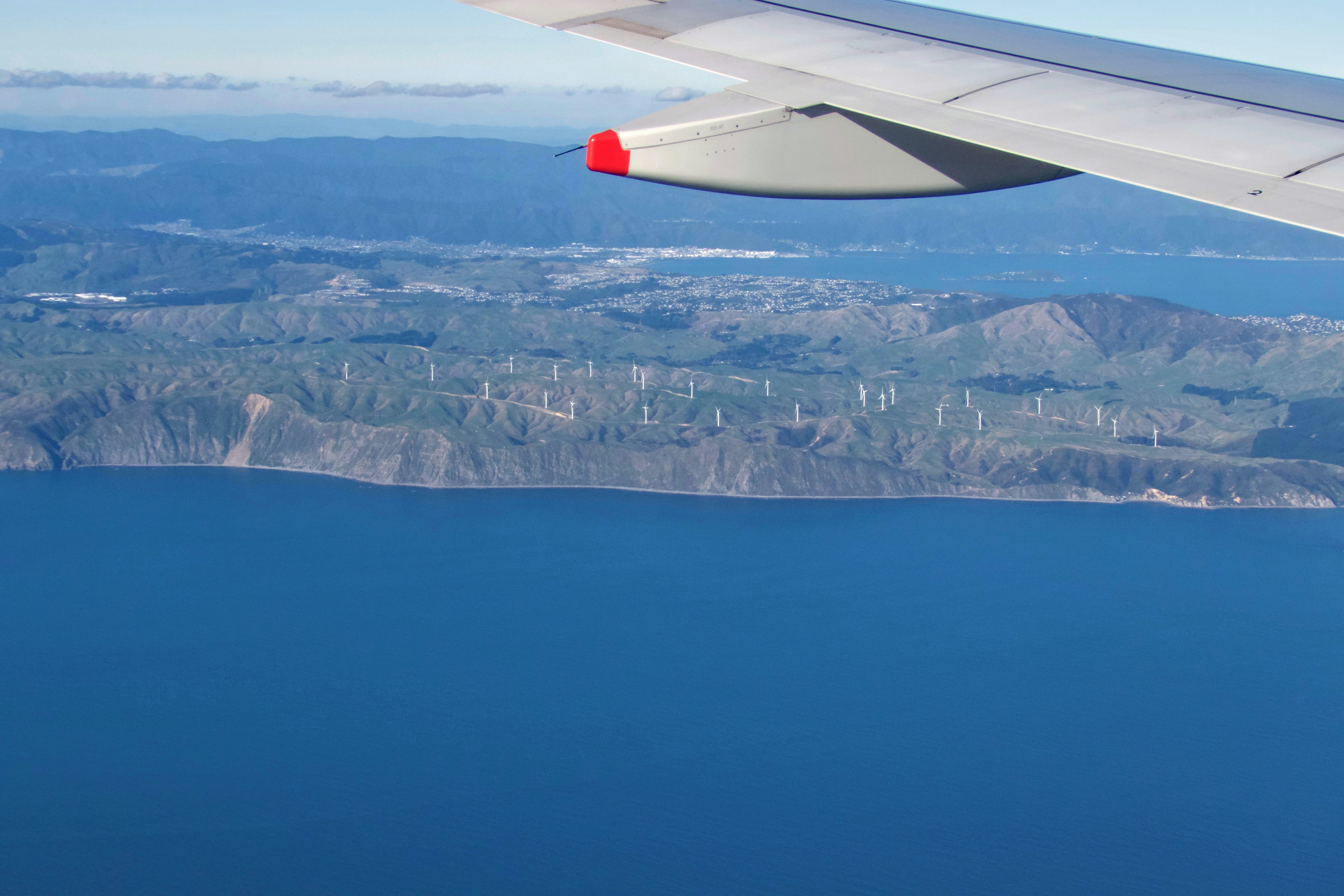 Coastal Windline: Wind Turbines Framing the Rugged Shore from an Airplane View