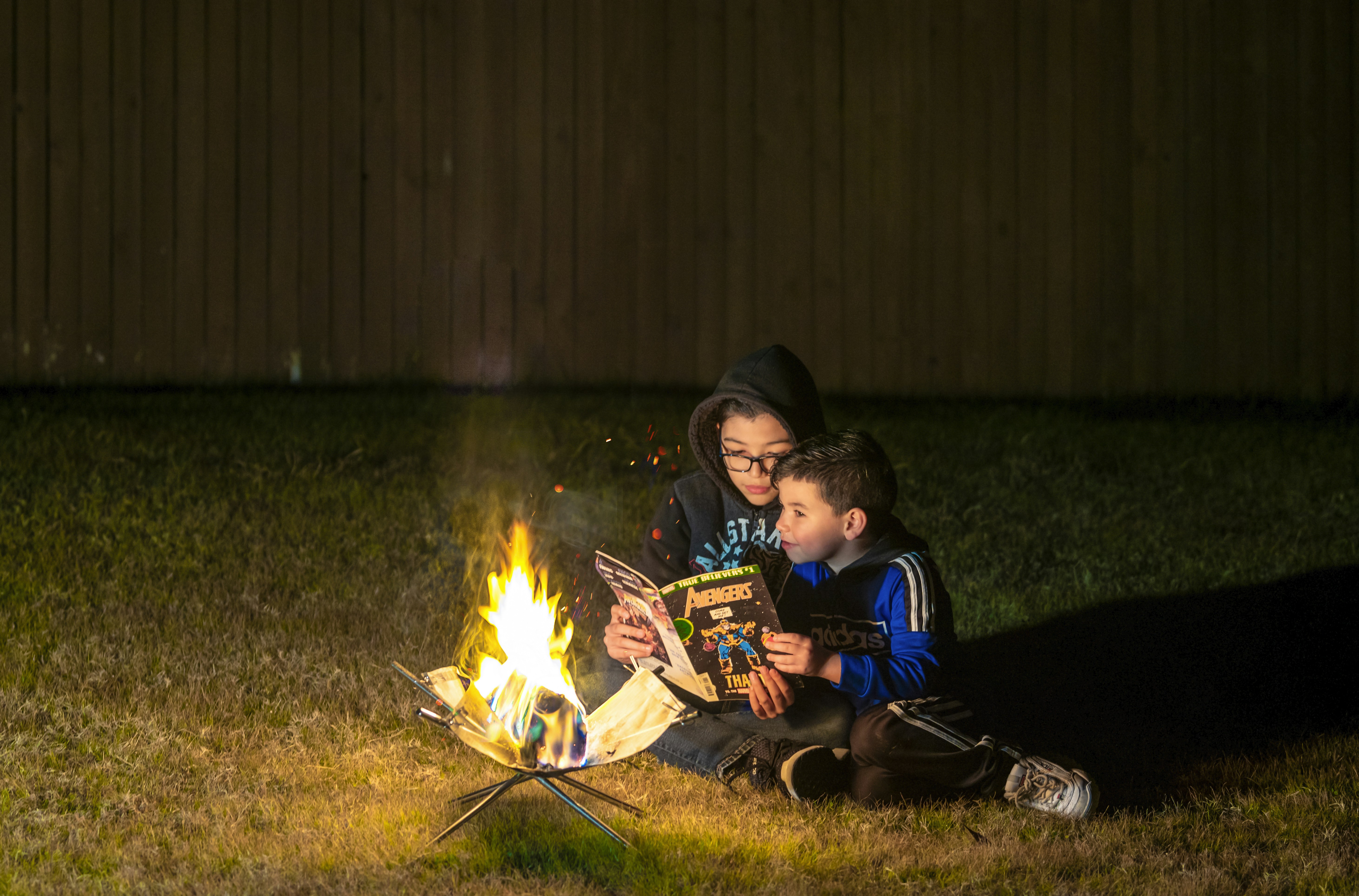Sibling Campfire Moment: Reading by Flamelight
