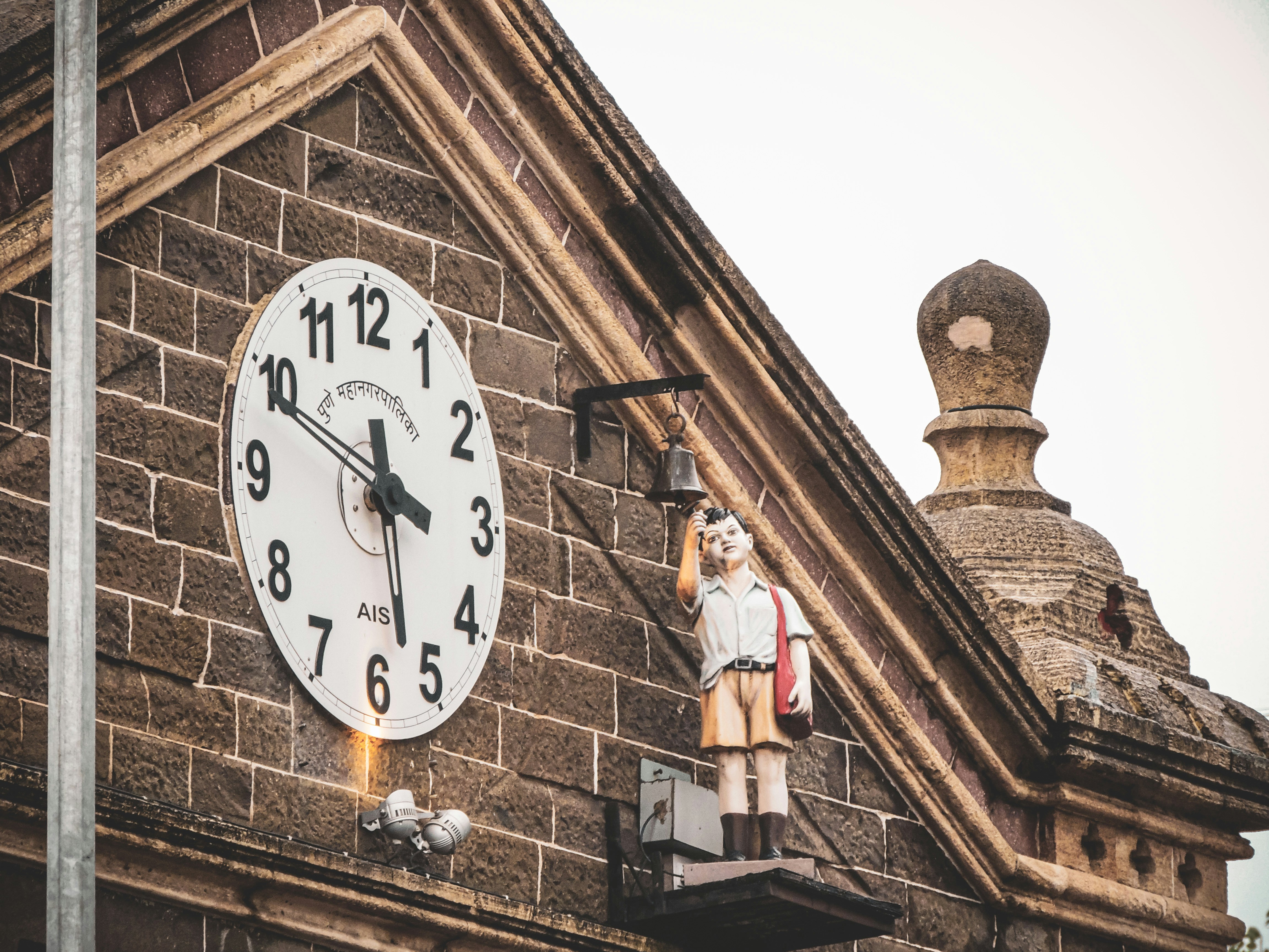 Time on a Brick Facade: A Clock That Watches Over a Toy Sentinel