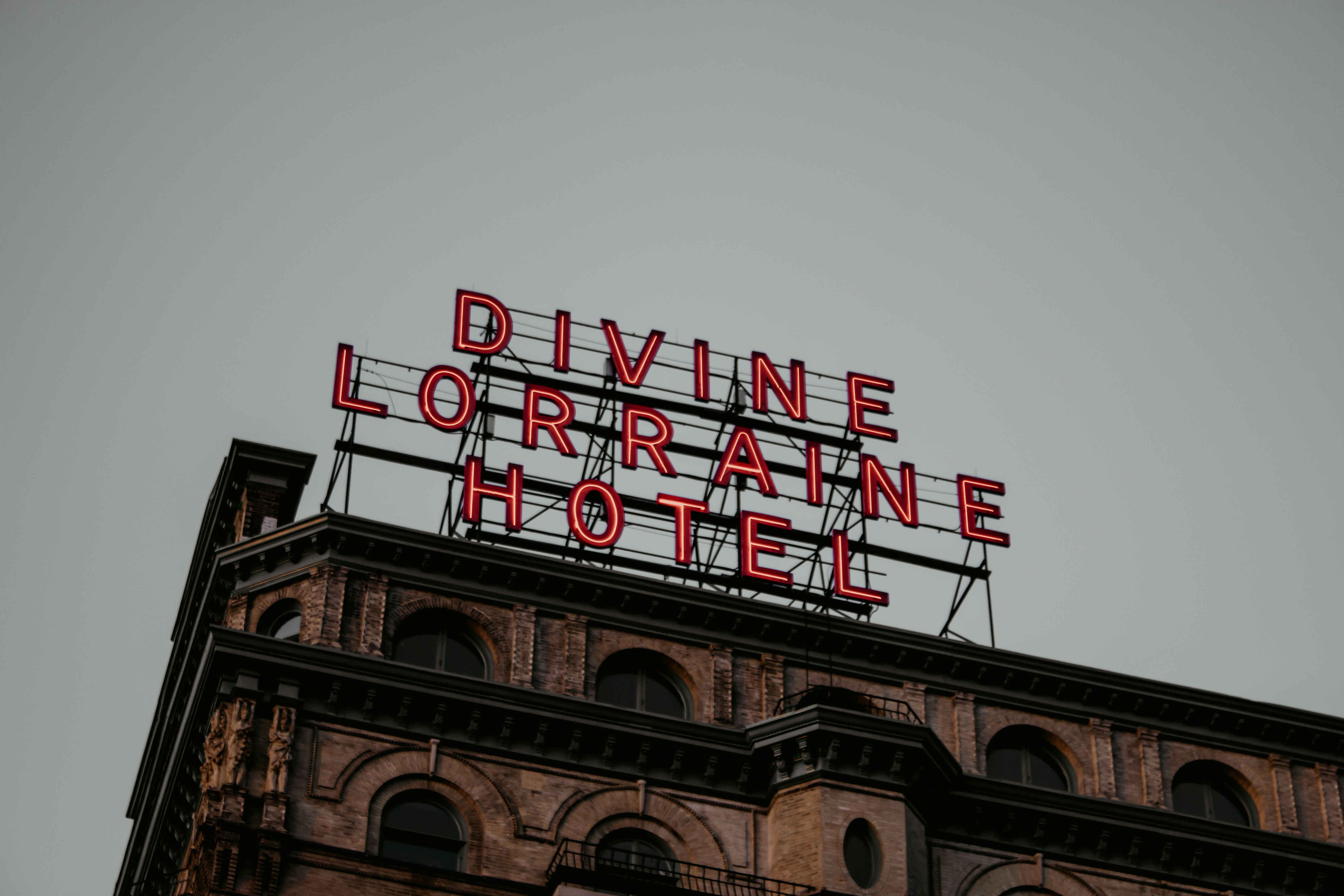 Historic building with a rooftop neon sign reading 'Divine Lorraine Hotel' against a muted sky.