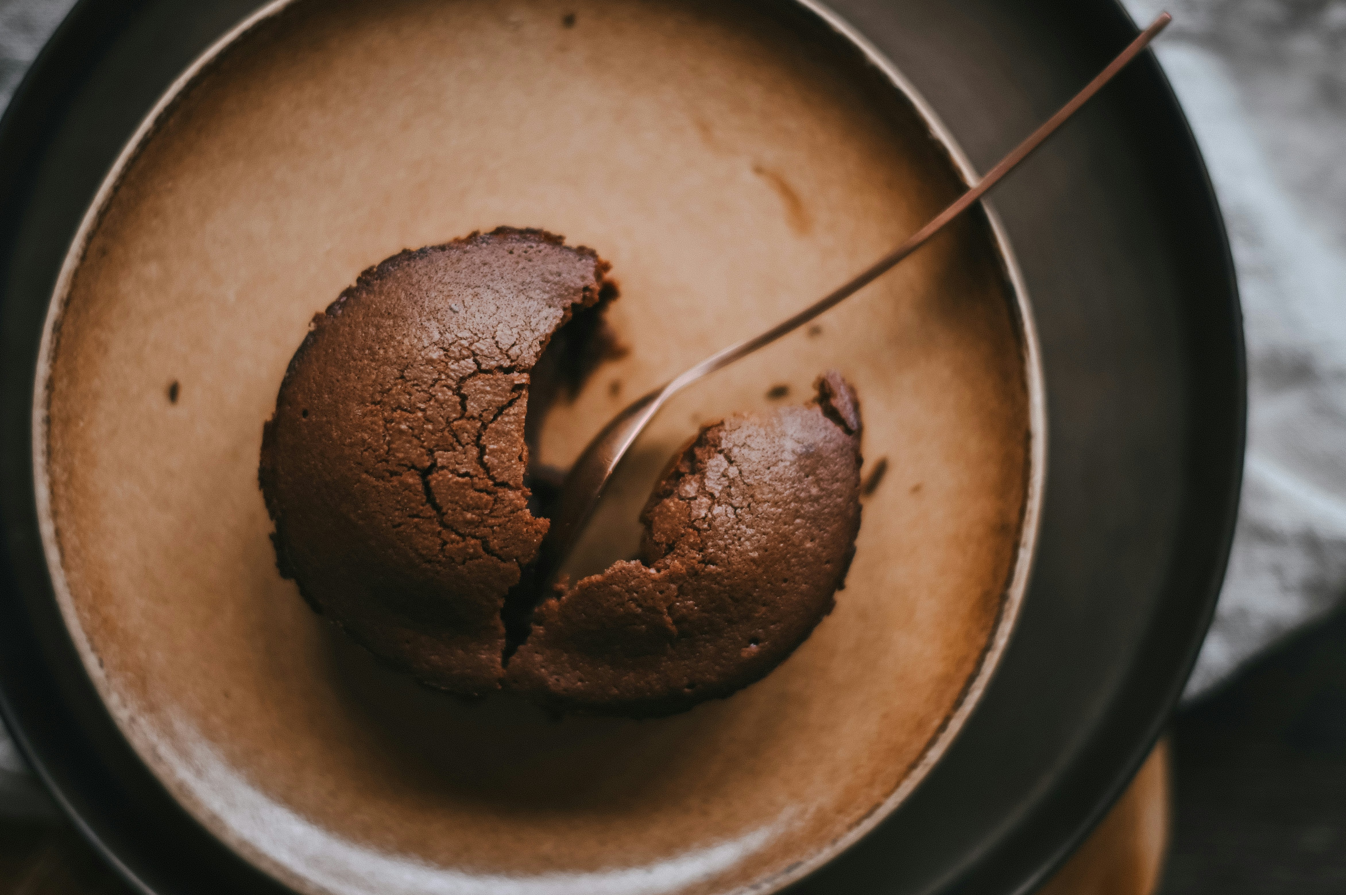 Molten chocolate cake with a spoon breaking through the crust.