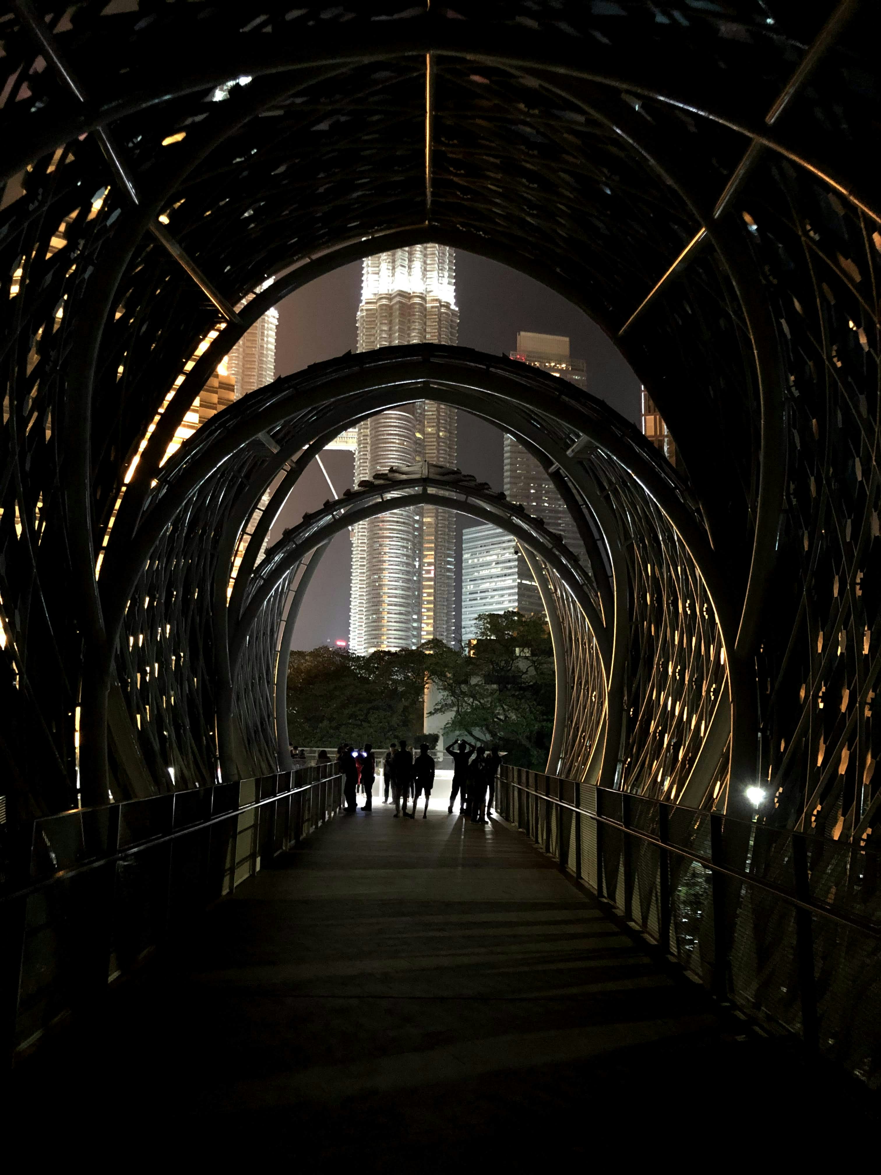 Ringed Nightway: Pedestrian Bridge Through Circular Arches Toward the City Lights