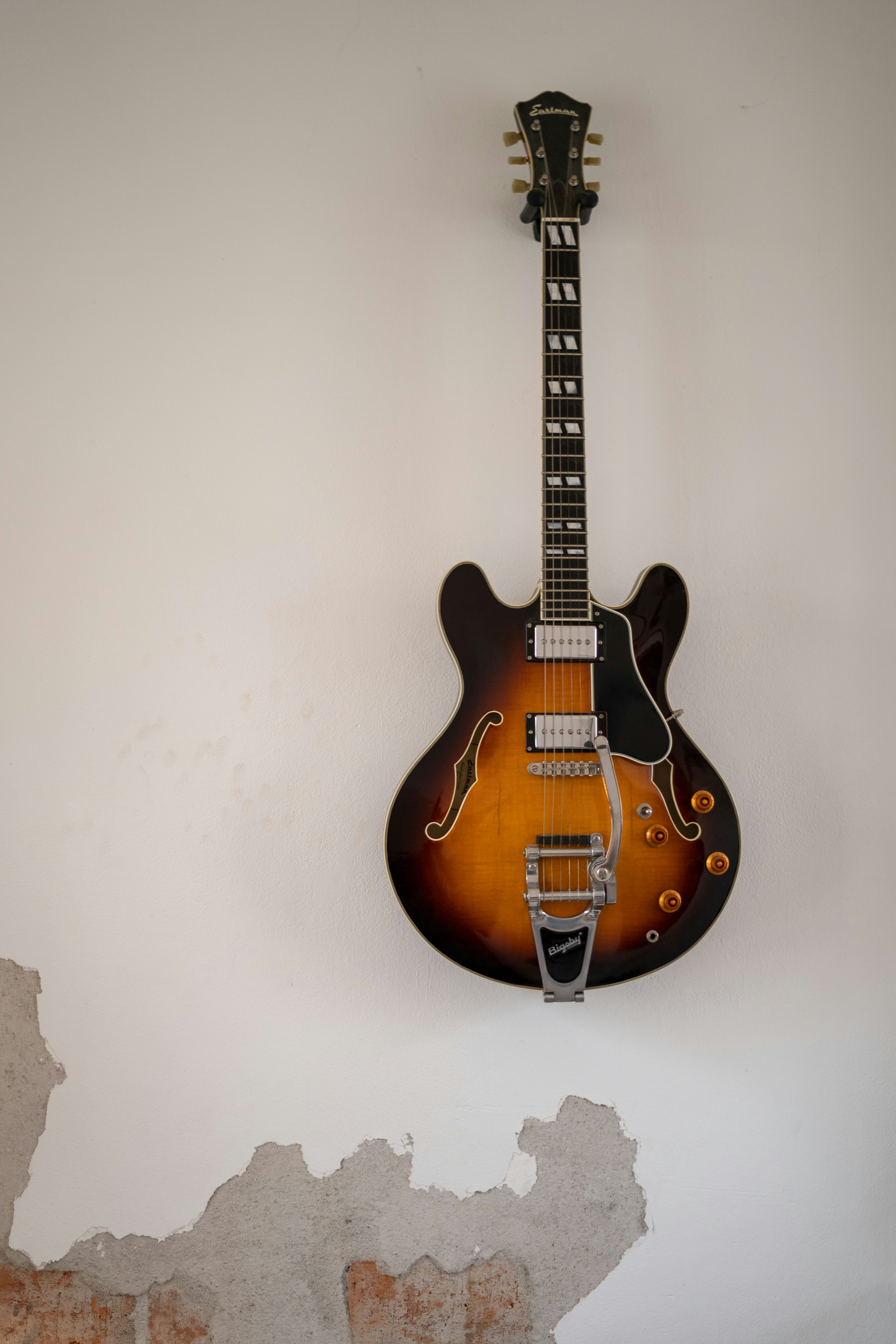 Eastman fireburnt guitar haning on industrial wall