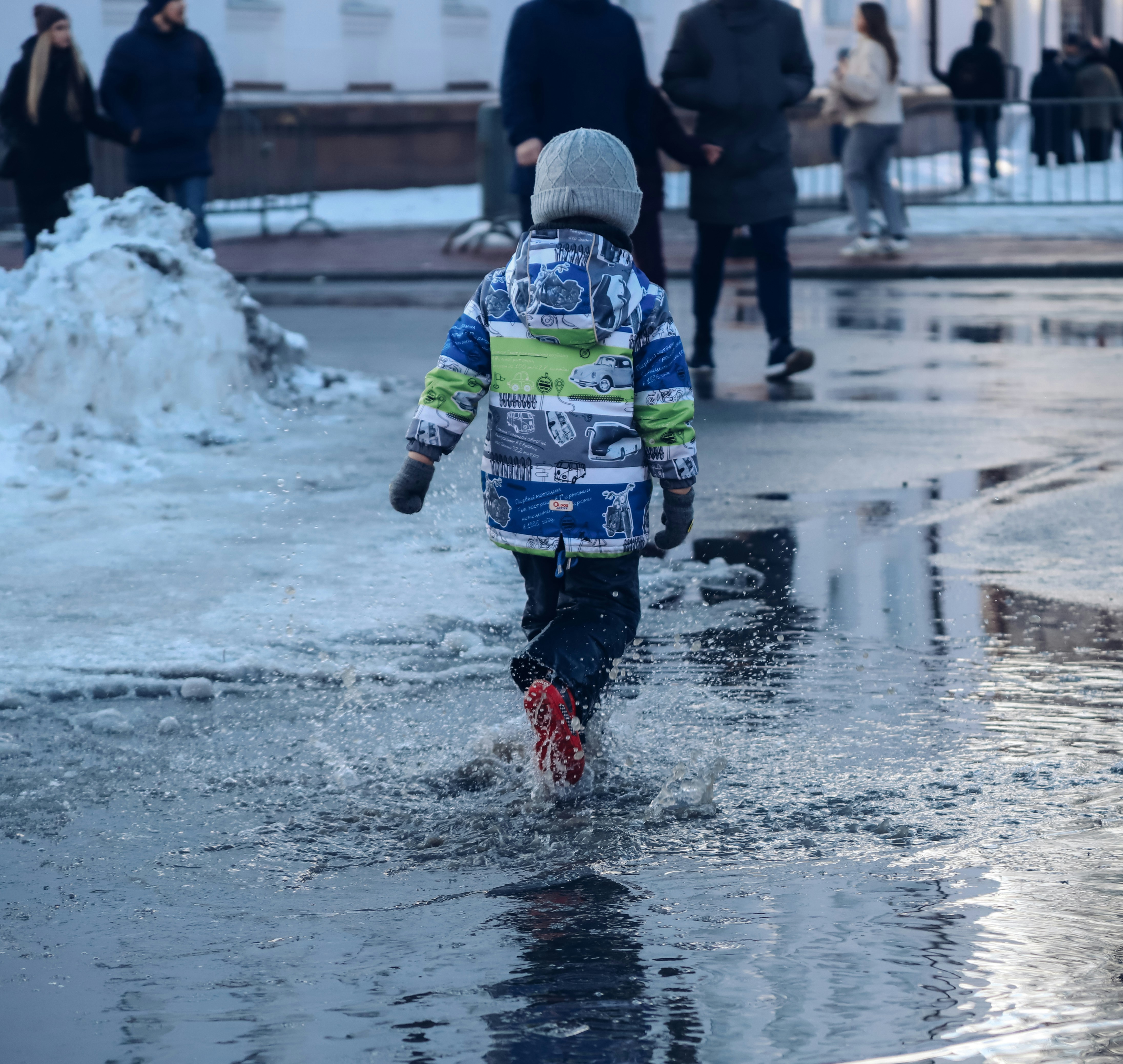 Puddle-Stride in a Snowy Plaza